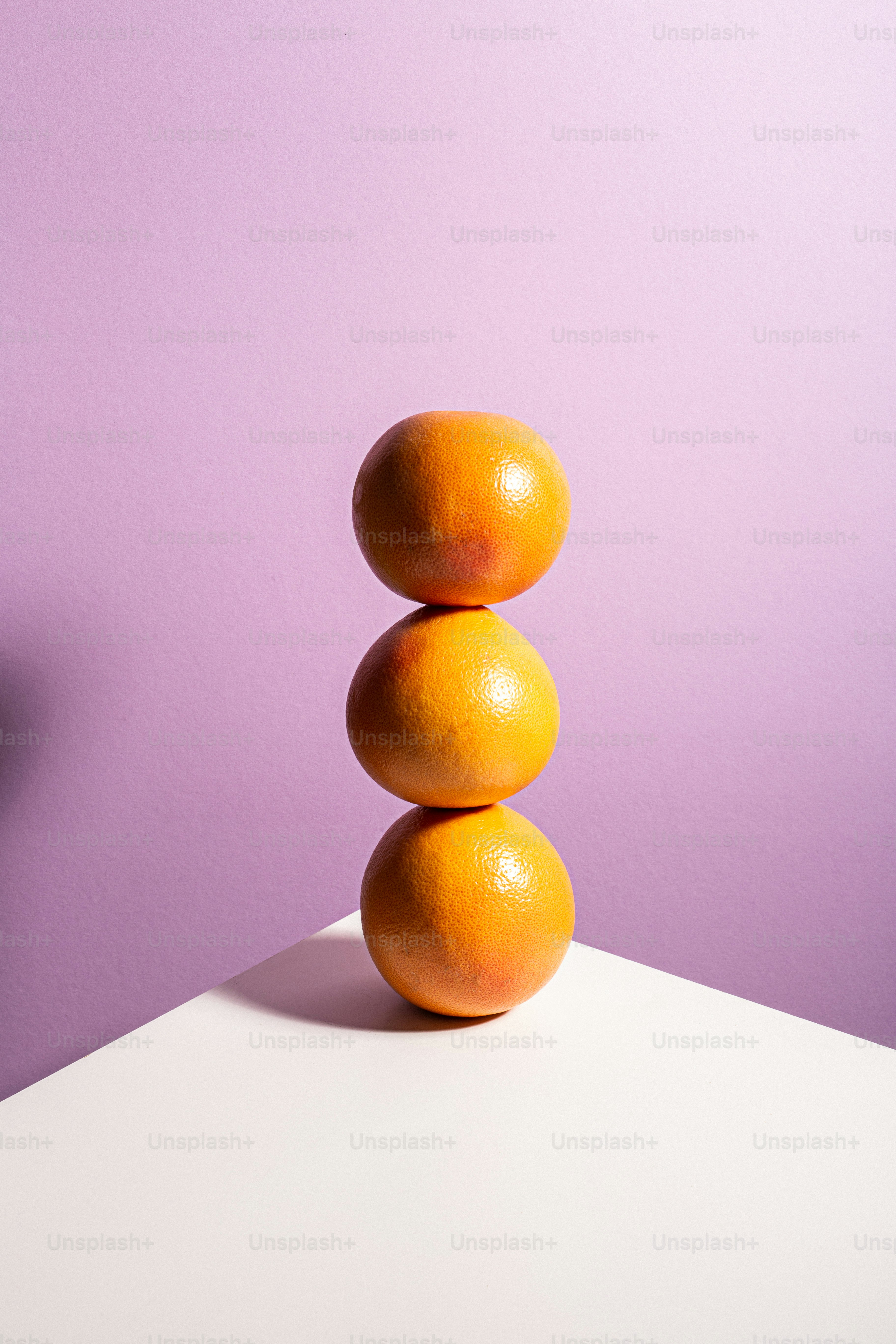A stack of oranges sitting on top of a white table photo – Fruits Image ...