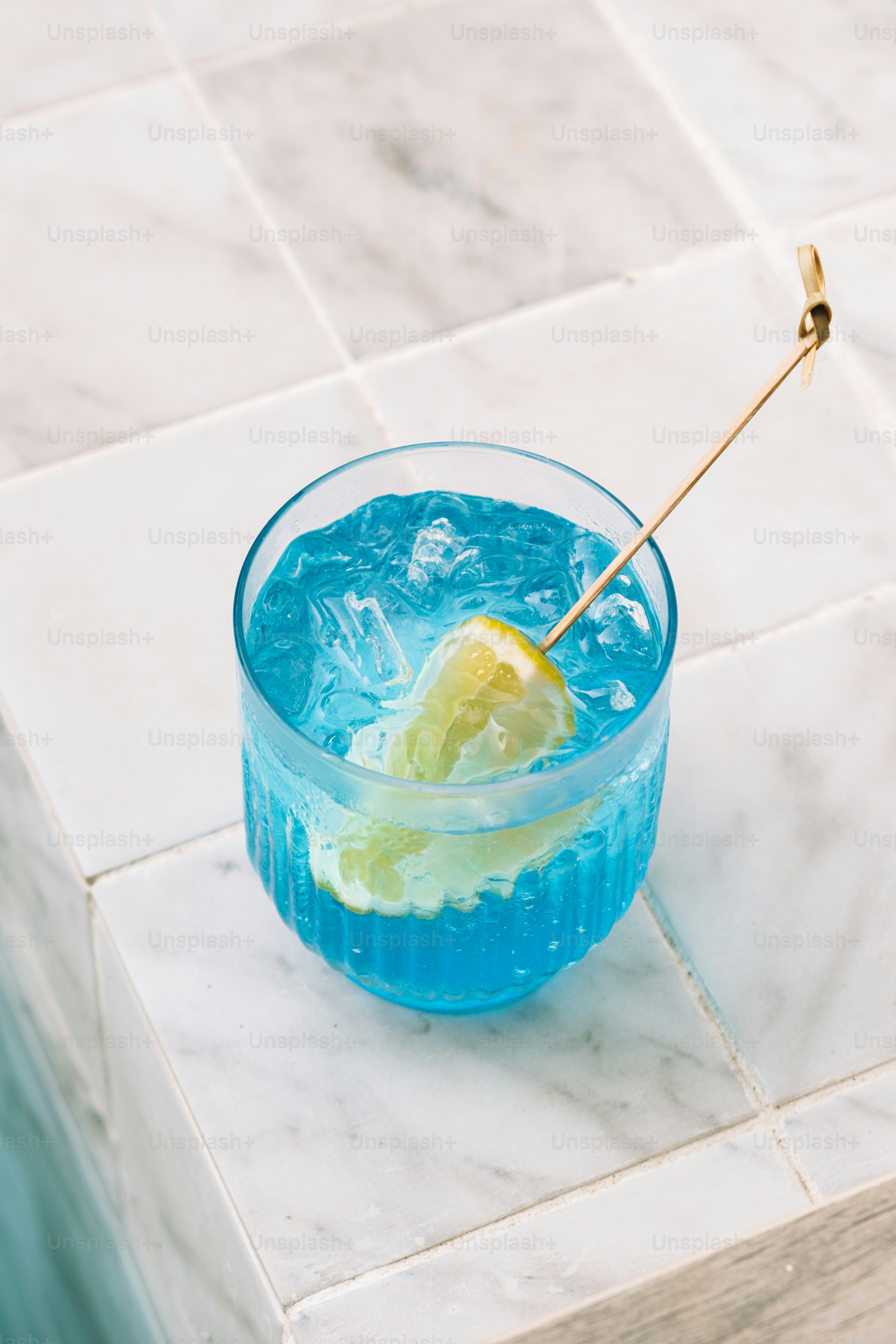 A blue drink with a lemon wedge in it photo – Cocktail Image on Unsplash