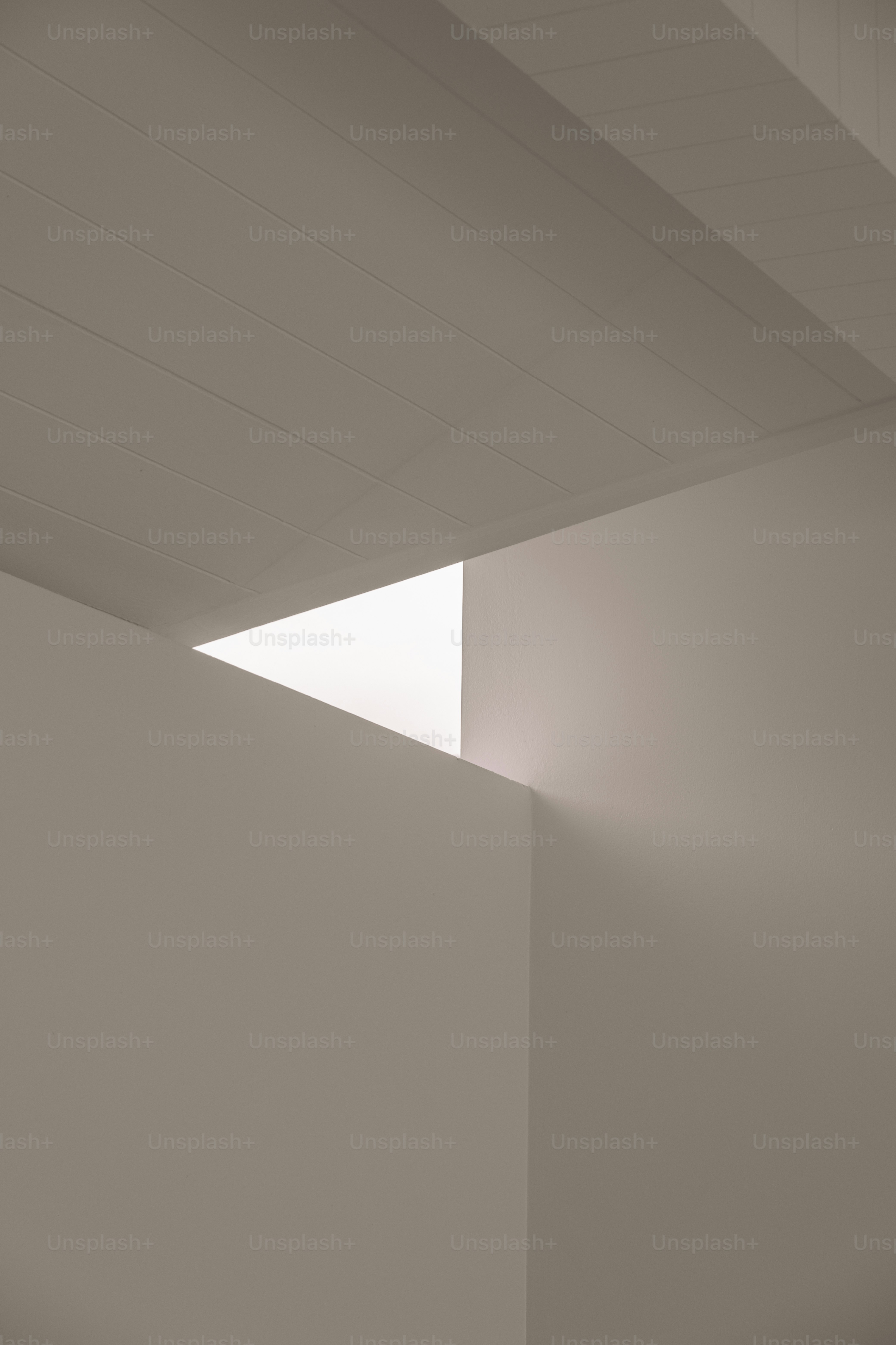 A white room with a light coming through the ceiling photo – Abstract ...