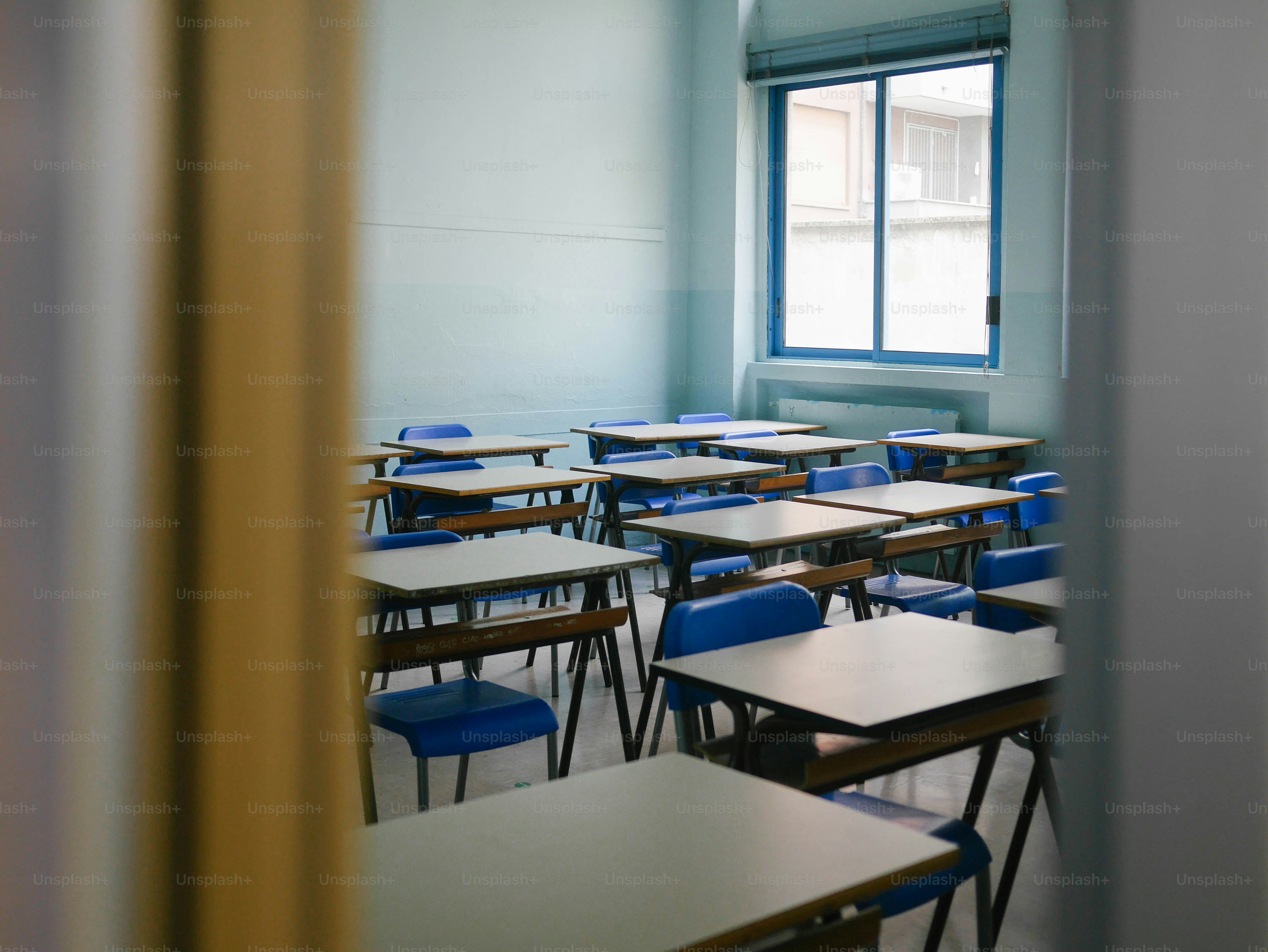 A classroom with desks and chairs and a window photo – School Image on ...