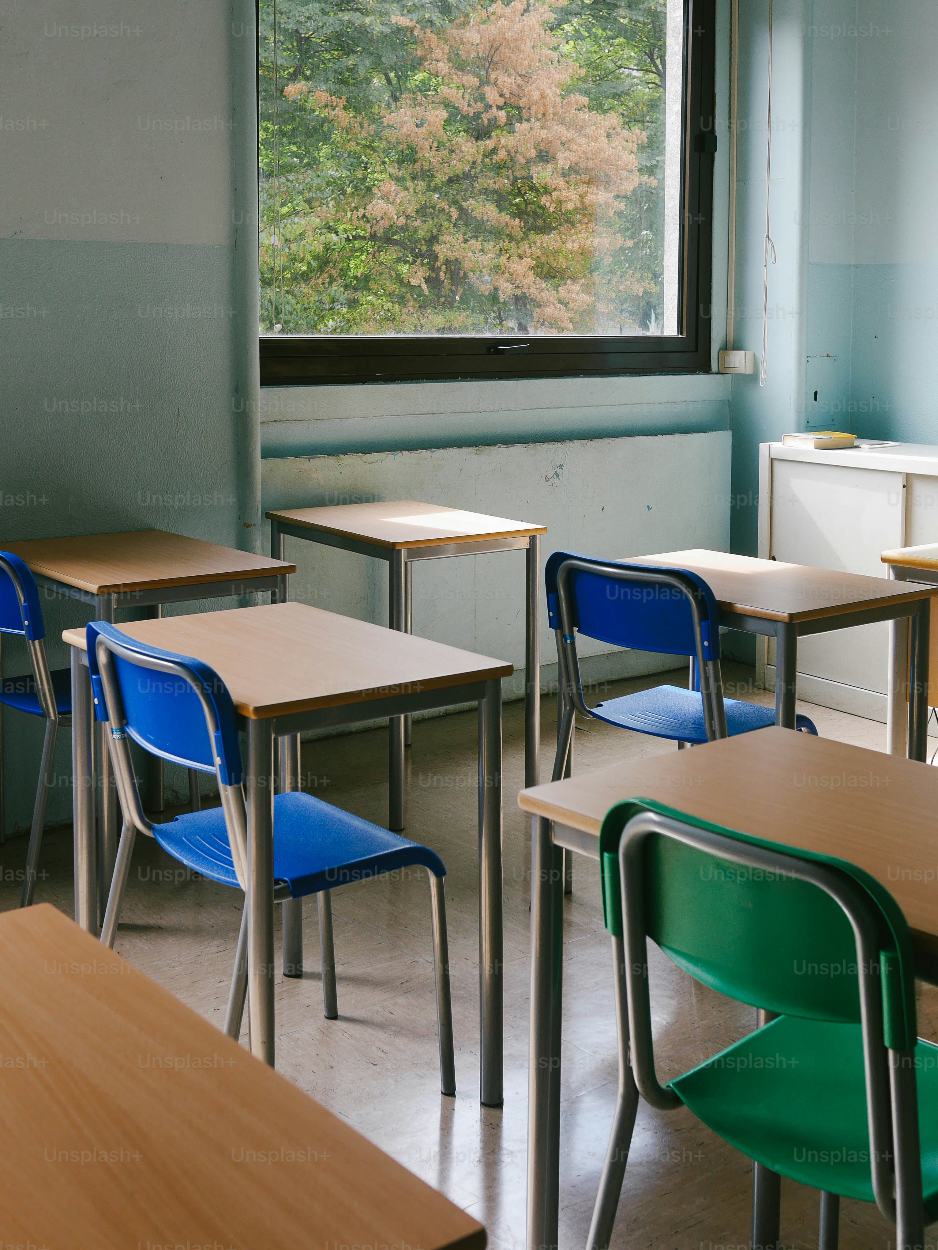 A classroom with desks and chairs and a window photo – Classroom Image ...