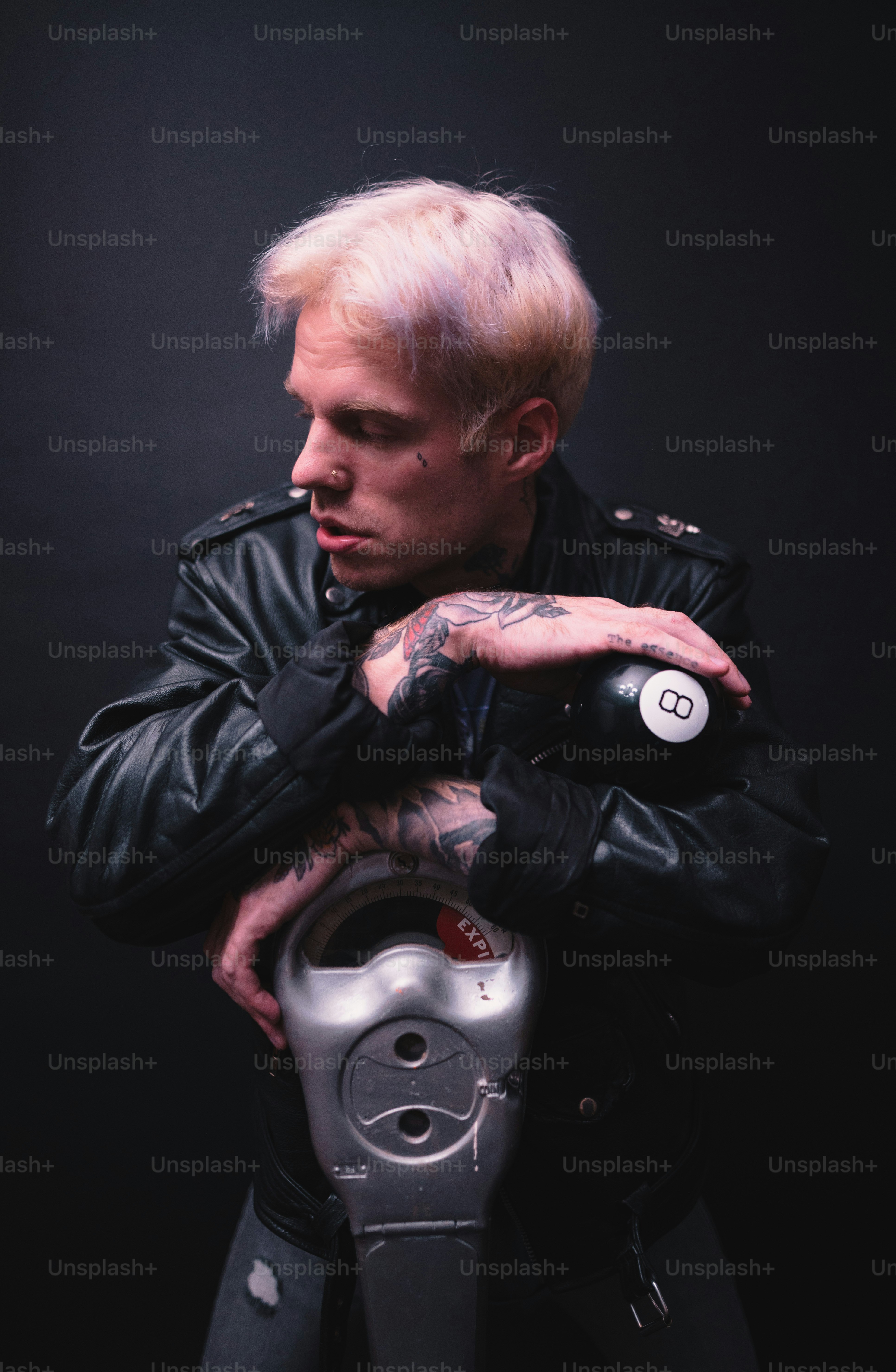 A man in a leather jacket holding a silver object photo – Model man ...