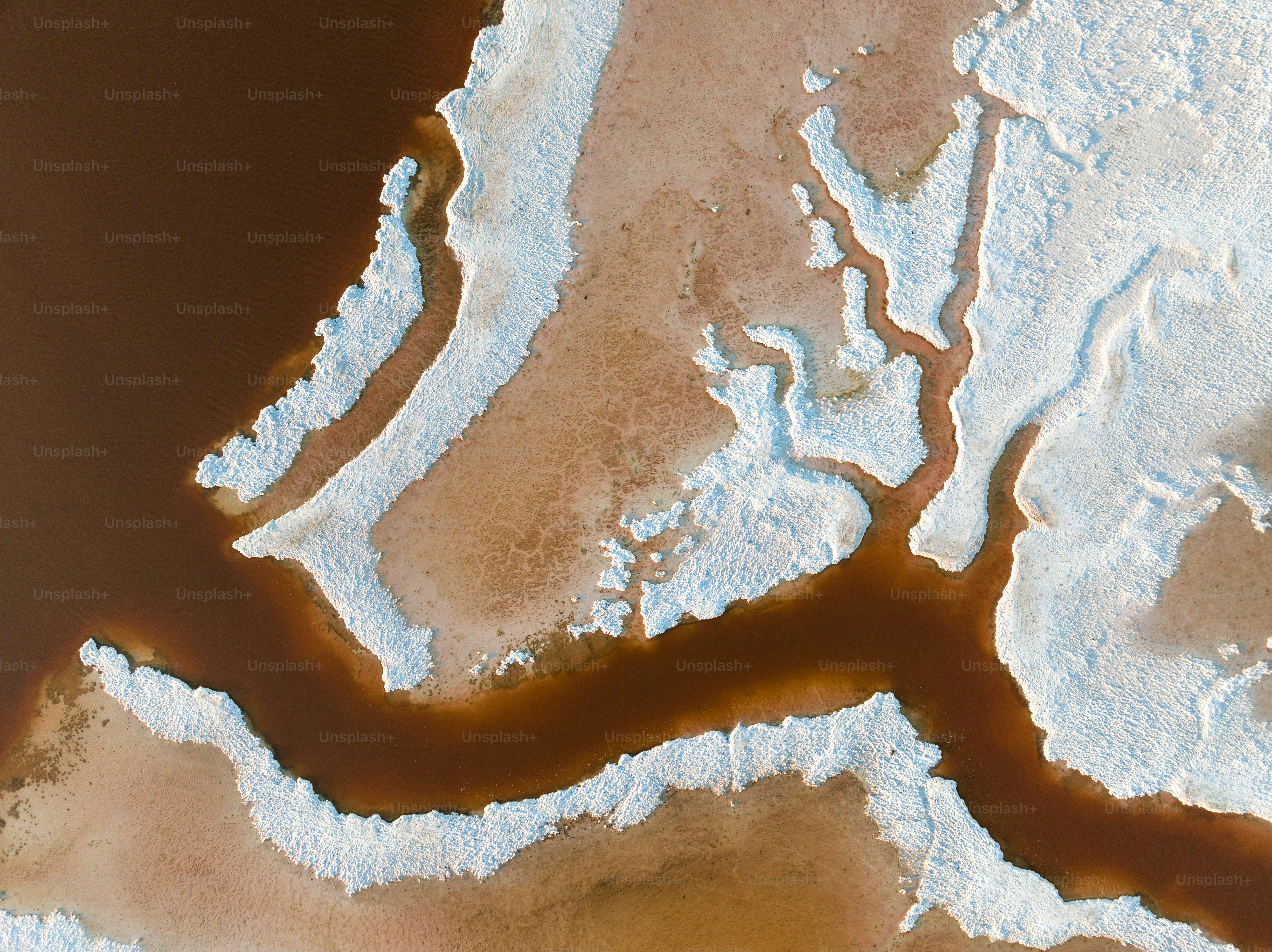 An aerial view of a body of water covered in red substance photo – Salt ...