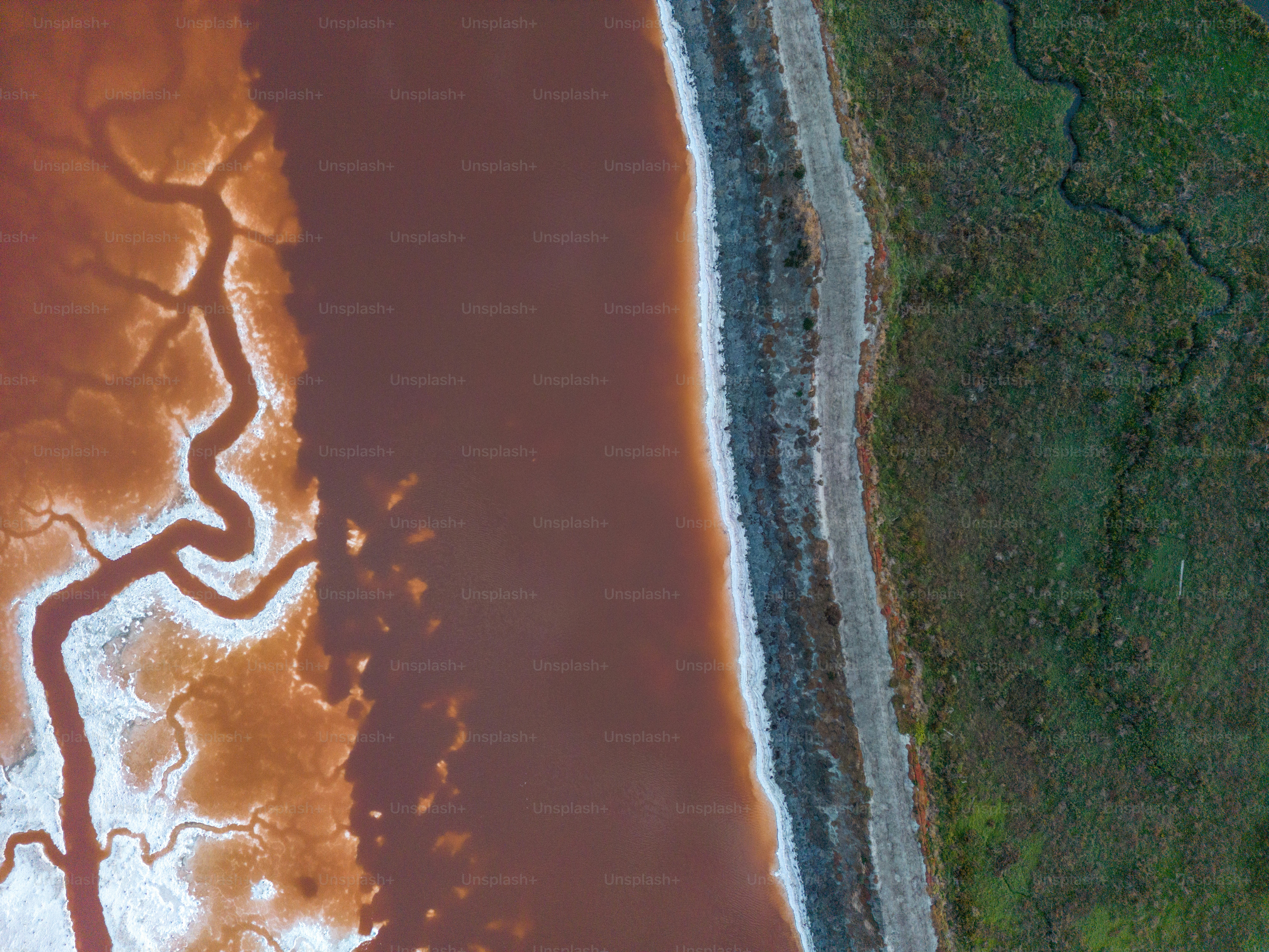 An aerial view of a body of water covered in red substance photo – Salt ...