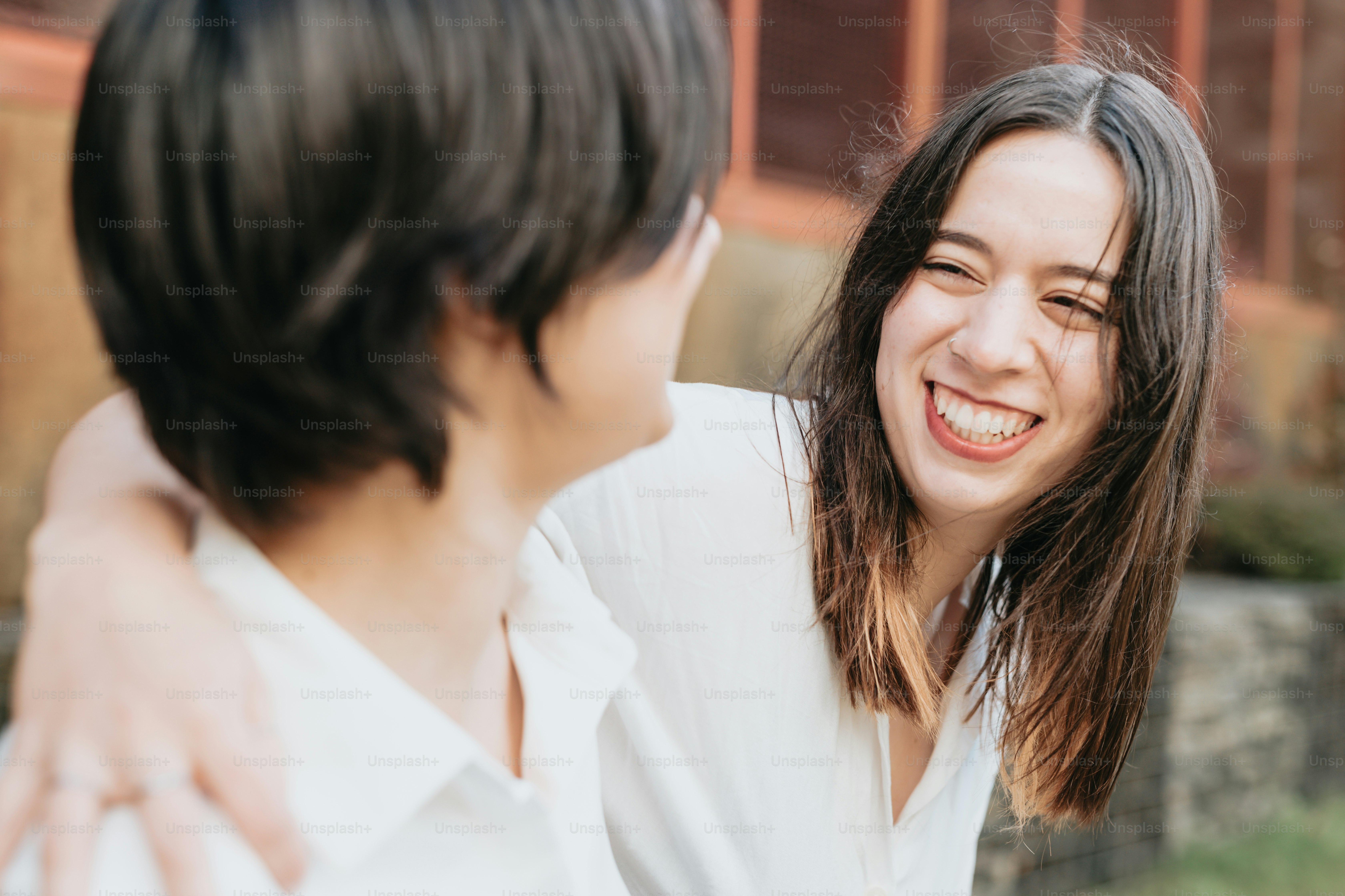 A woman is smiling and talking to another woman photo – Business Image ...