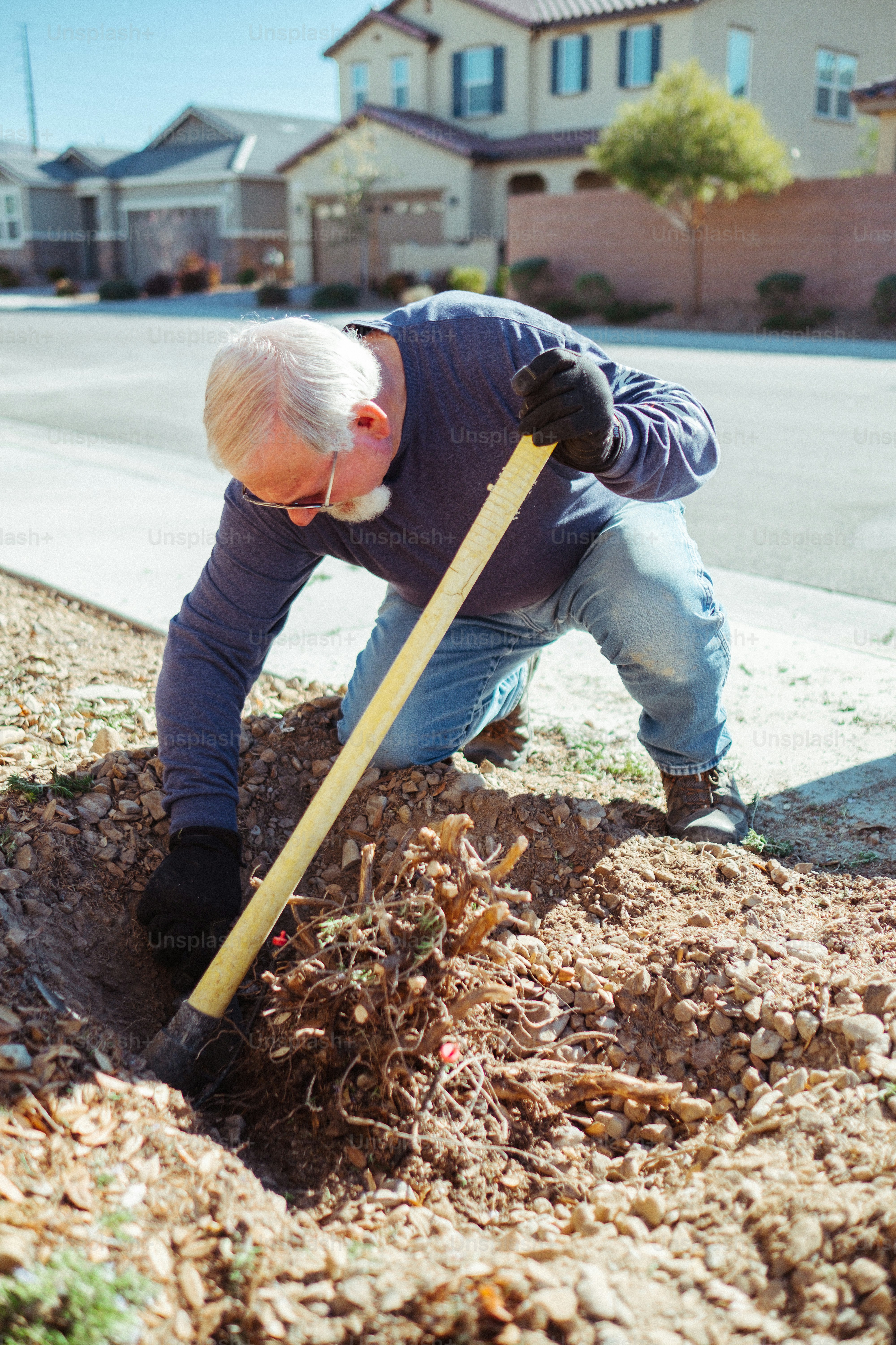 A man digging a hole in the ground photo – Gardening Image on Unsplash