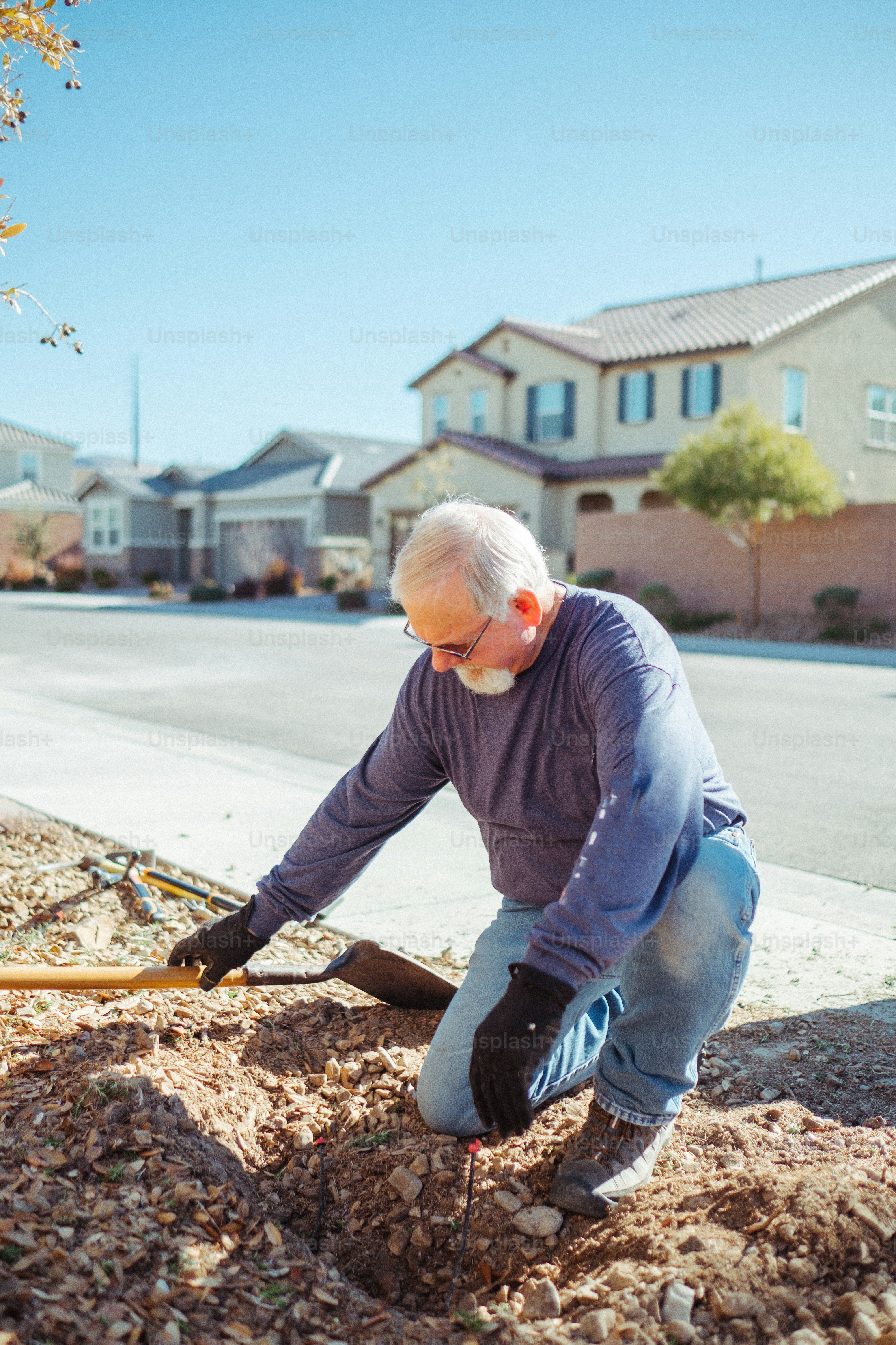 Foto Un hombre está cavando un hoyo en el suelo – Jardinería Imagen en ...