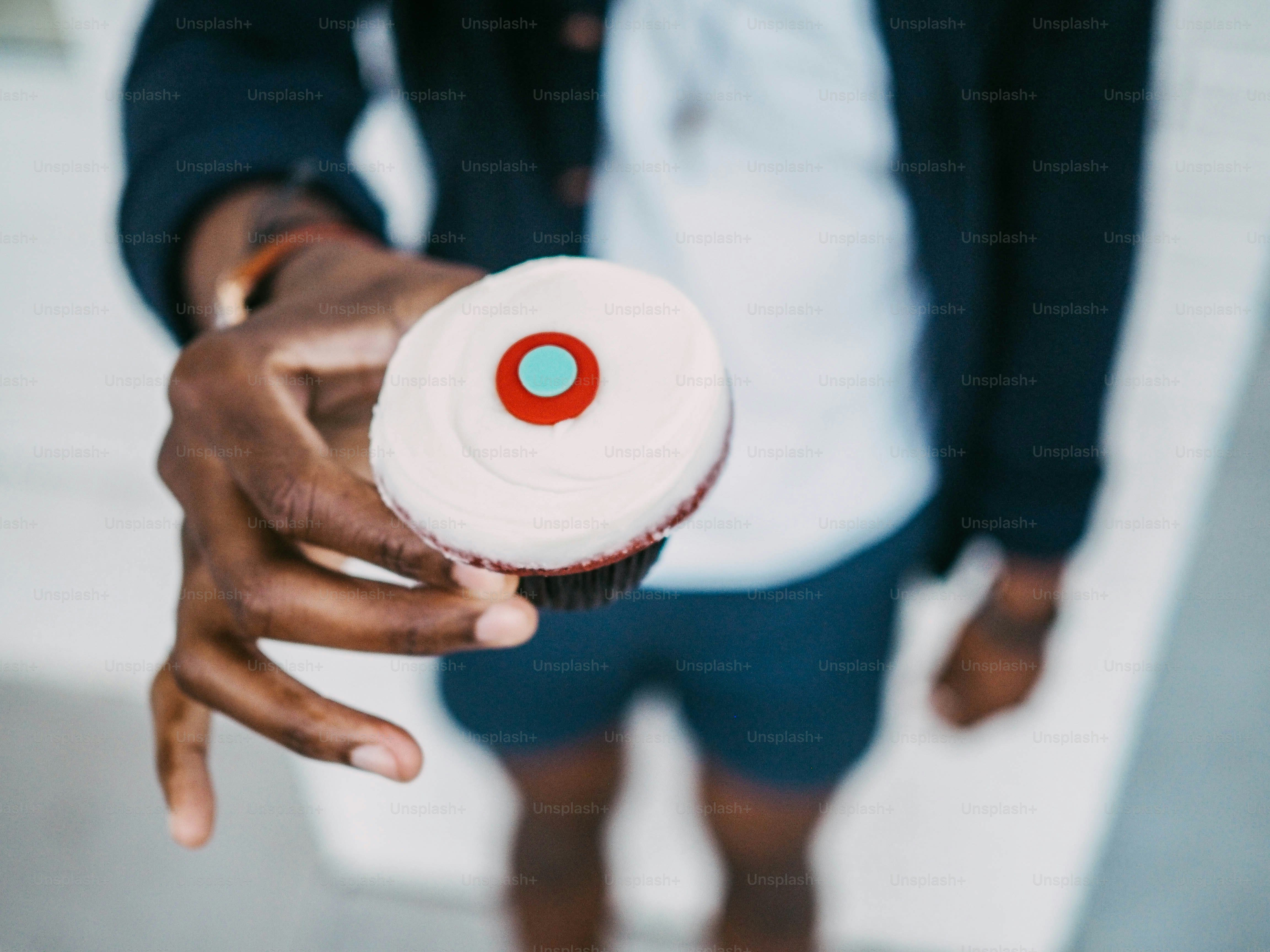 A close up of a person holding a cupcake photo – Cake Image on Unsplash