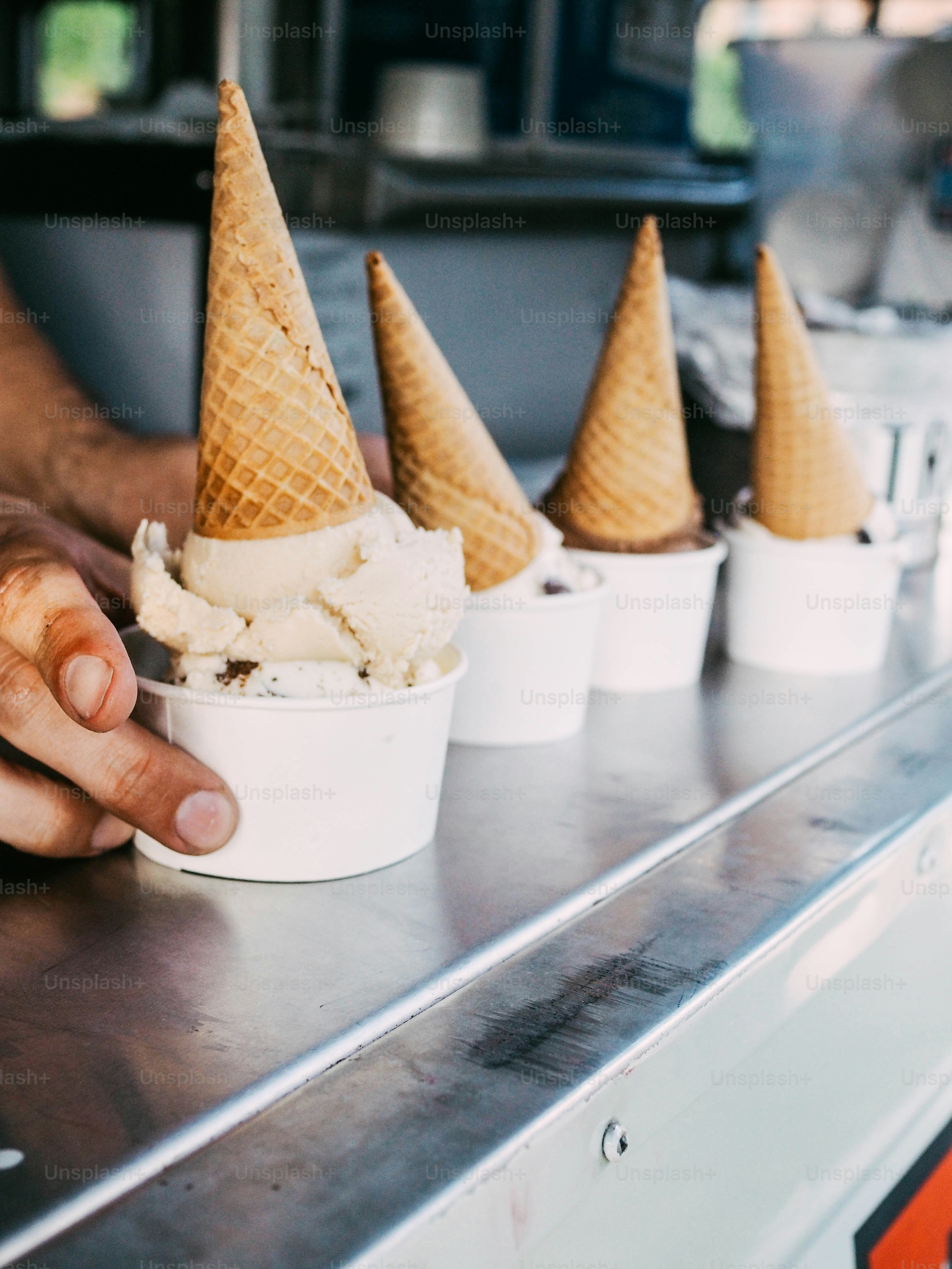 A hand reaching for an ice cream cone photo – Ice cream Image on Unsplash