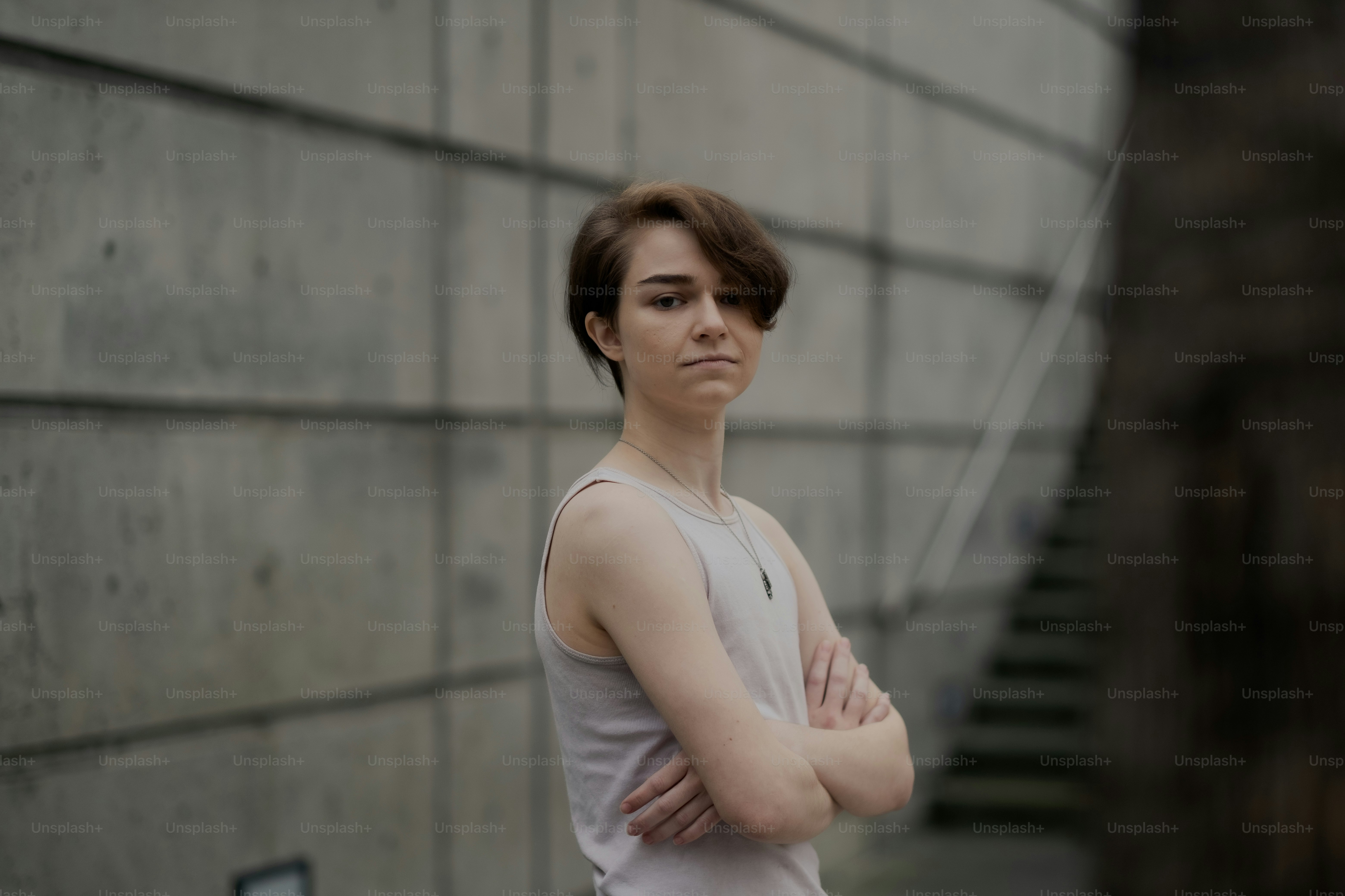 A woman standing in front of a wall with her arms crossed photo ...