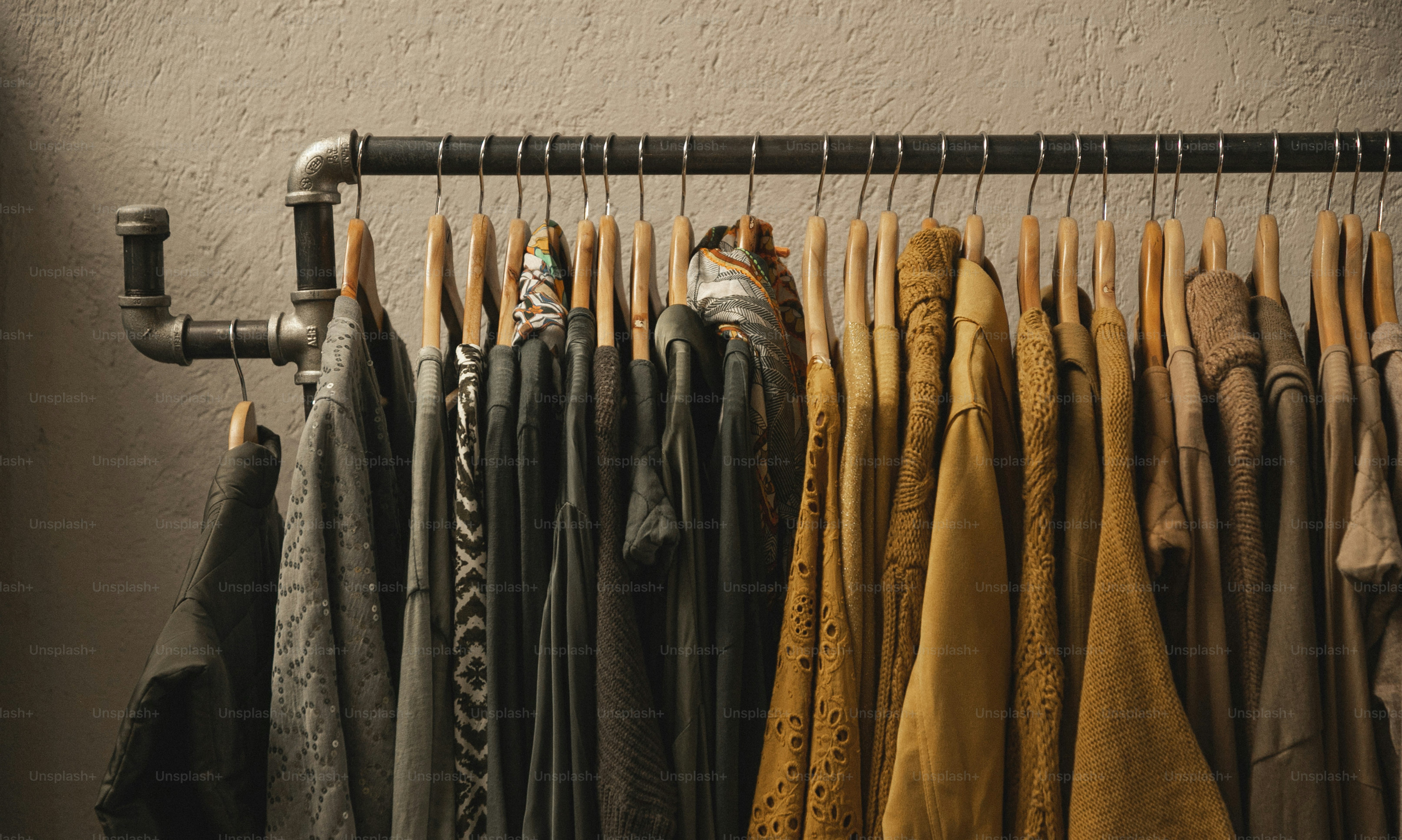A rack of clothes hanging on a wall photo – Clothing rack Image on Unsplash