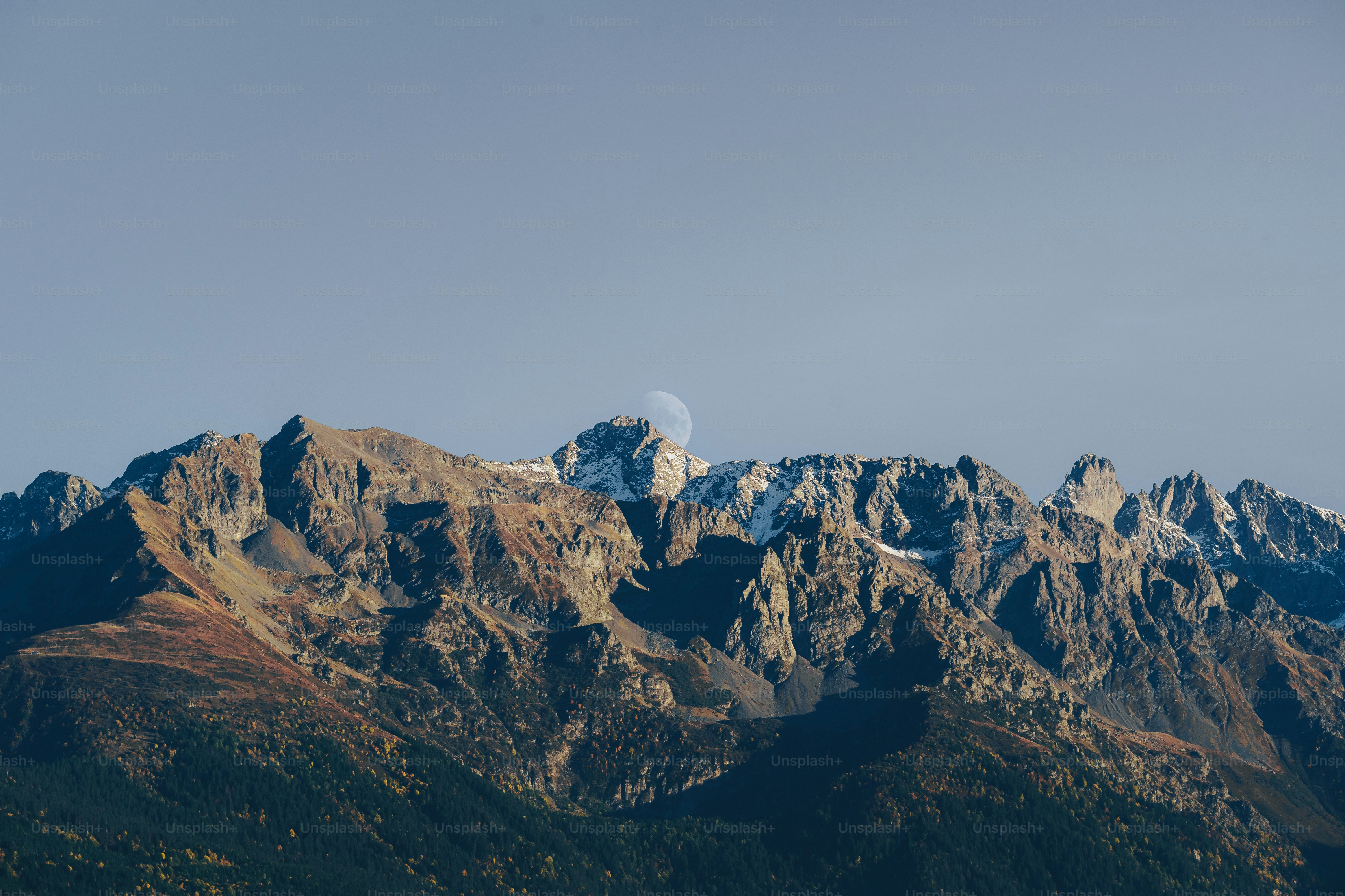 A view of a mountain range with a moon in the sky photo – Moon forest ...