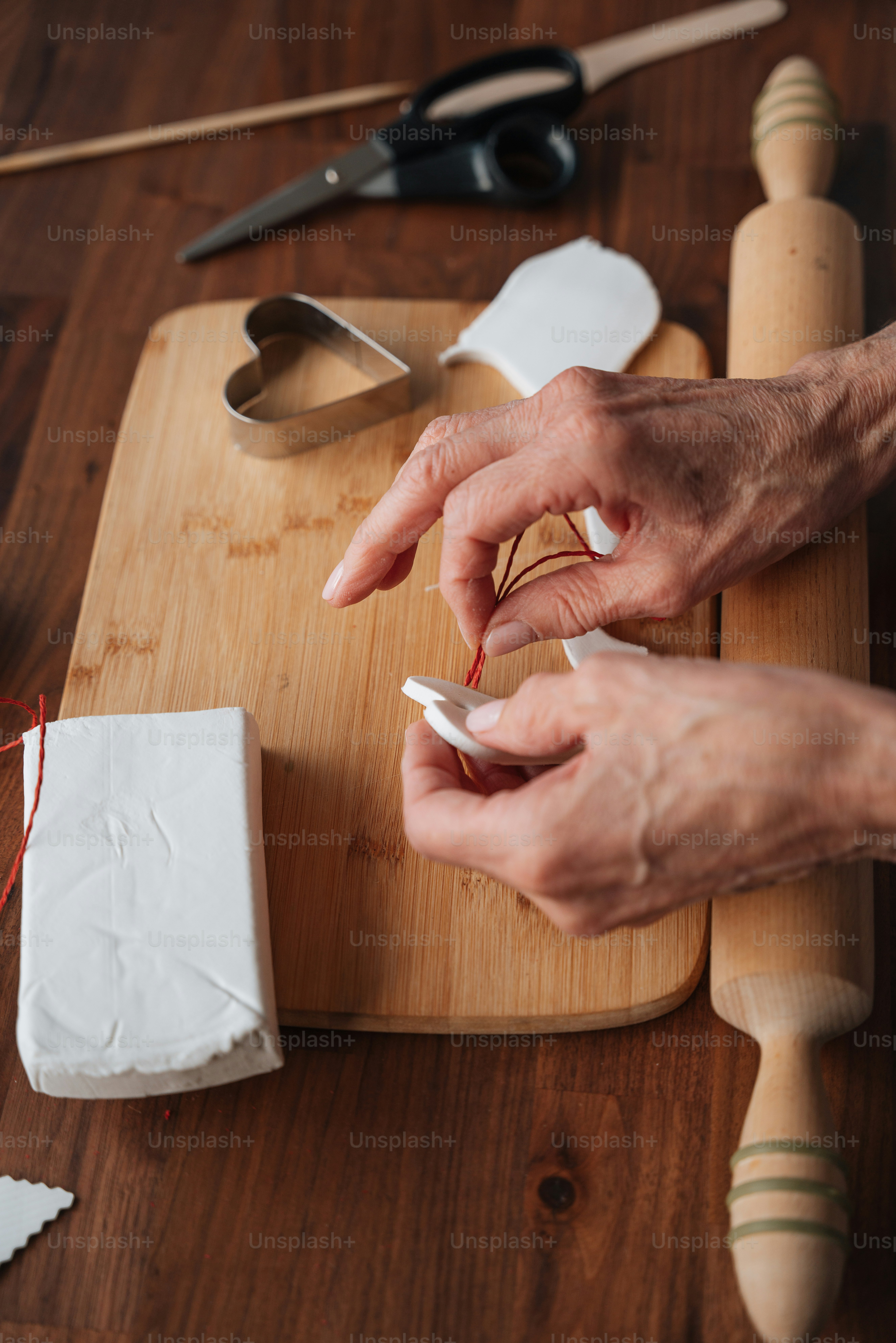 A person using a cell phone on a cutting board photo – Clay making ...