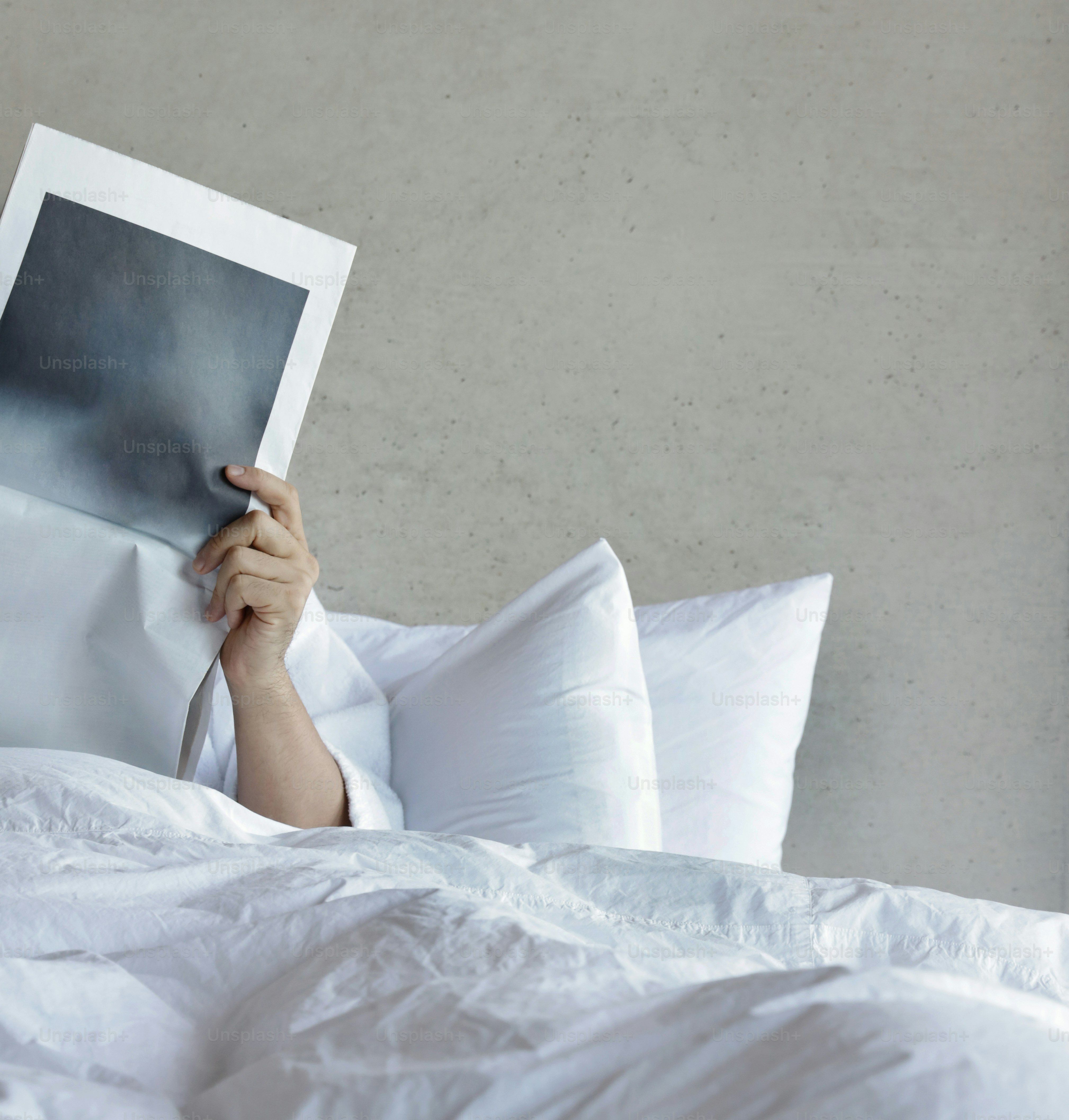 Foto Una persona acostada en la cama leyendo un libro – Renovar Imagen ...