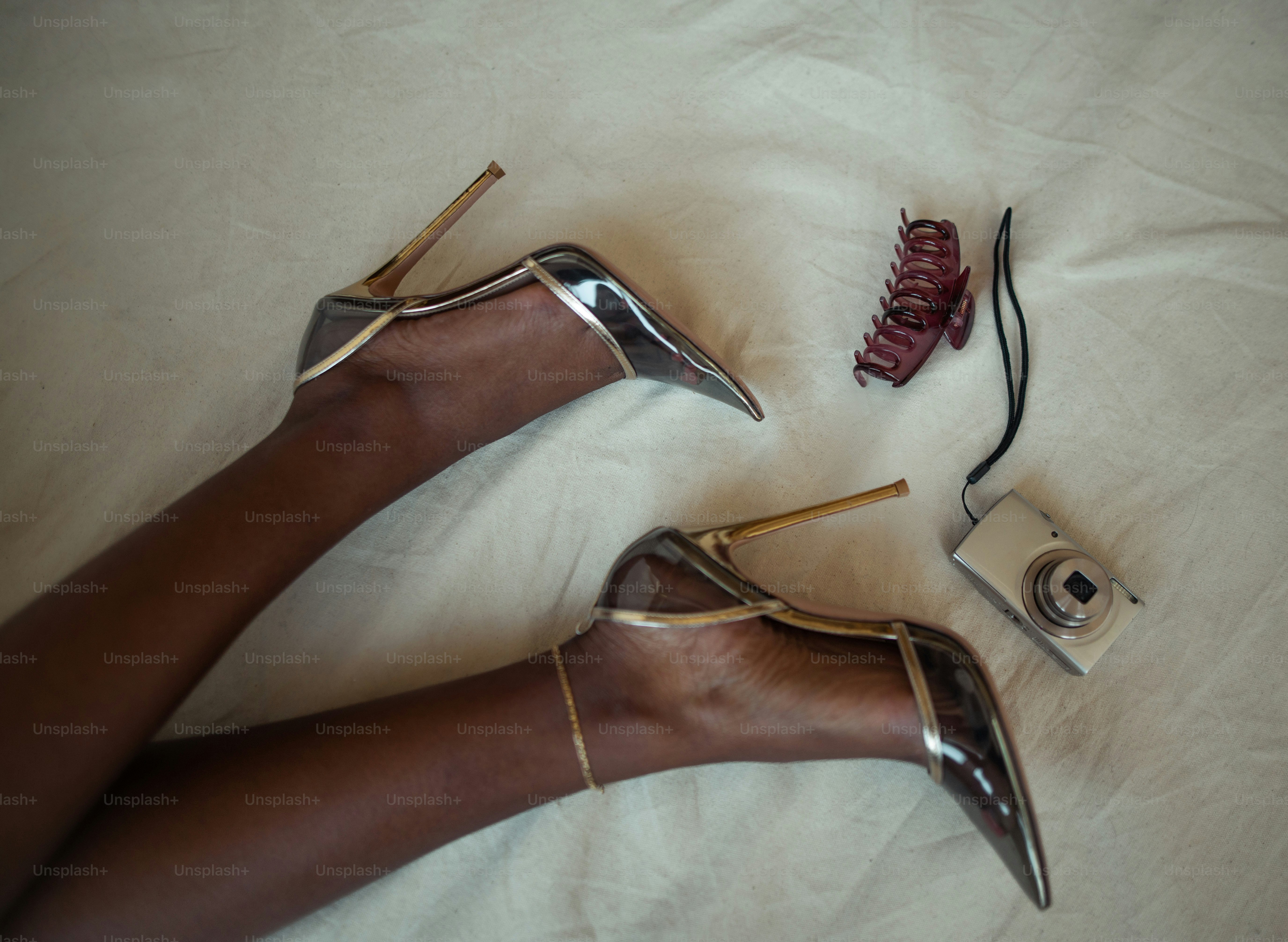 Une paire de jambes de femme avec des talons hauts et un appareil photo ...