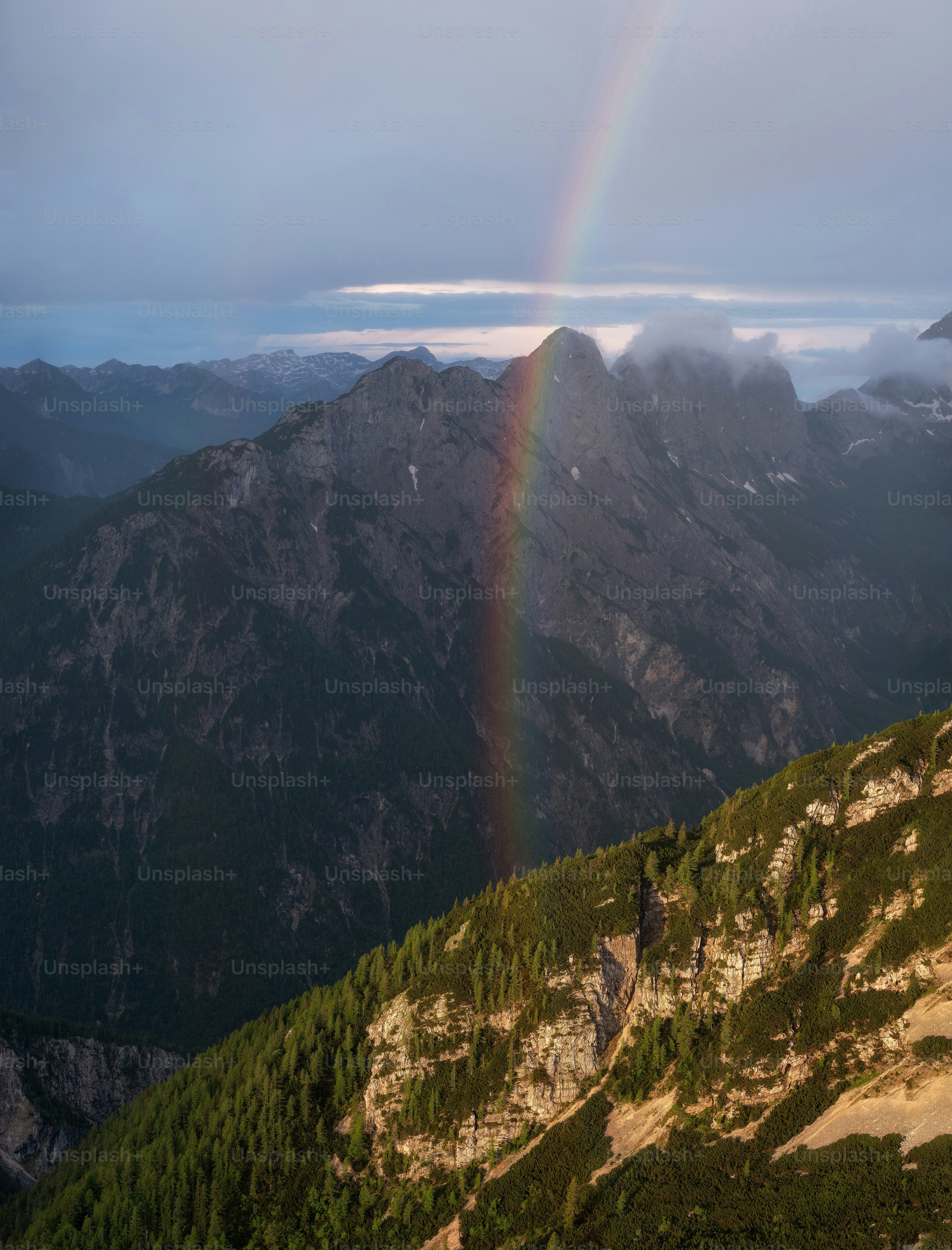 A rainbow in the sky over a mountain range photo – Rainbow mountain ...
