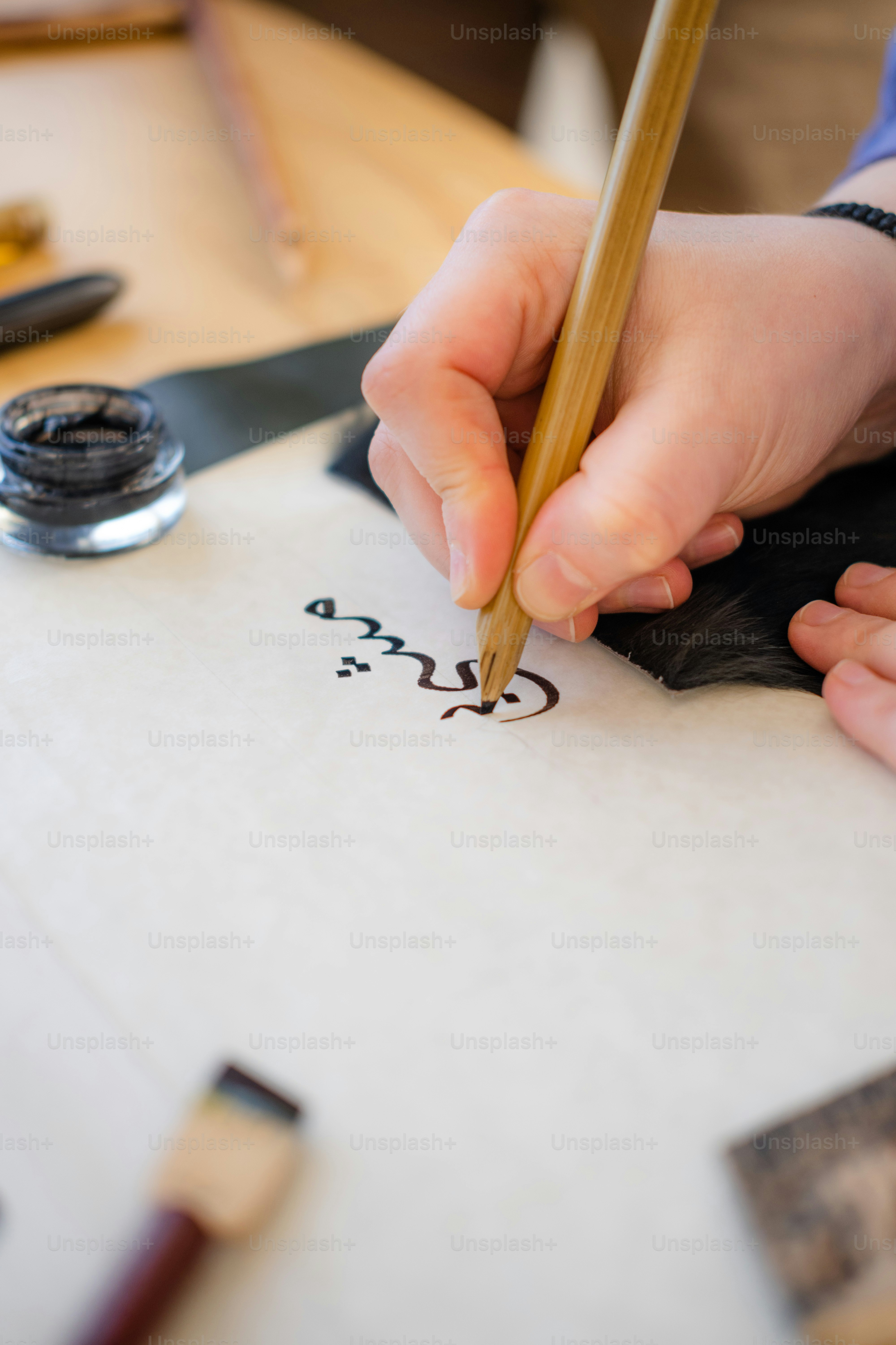 Une personne écrivant sur un morceau de papier avec un crayon photo ...
