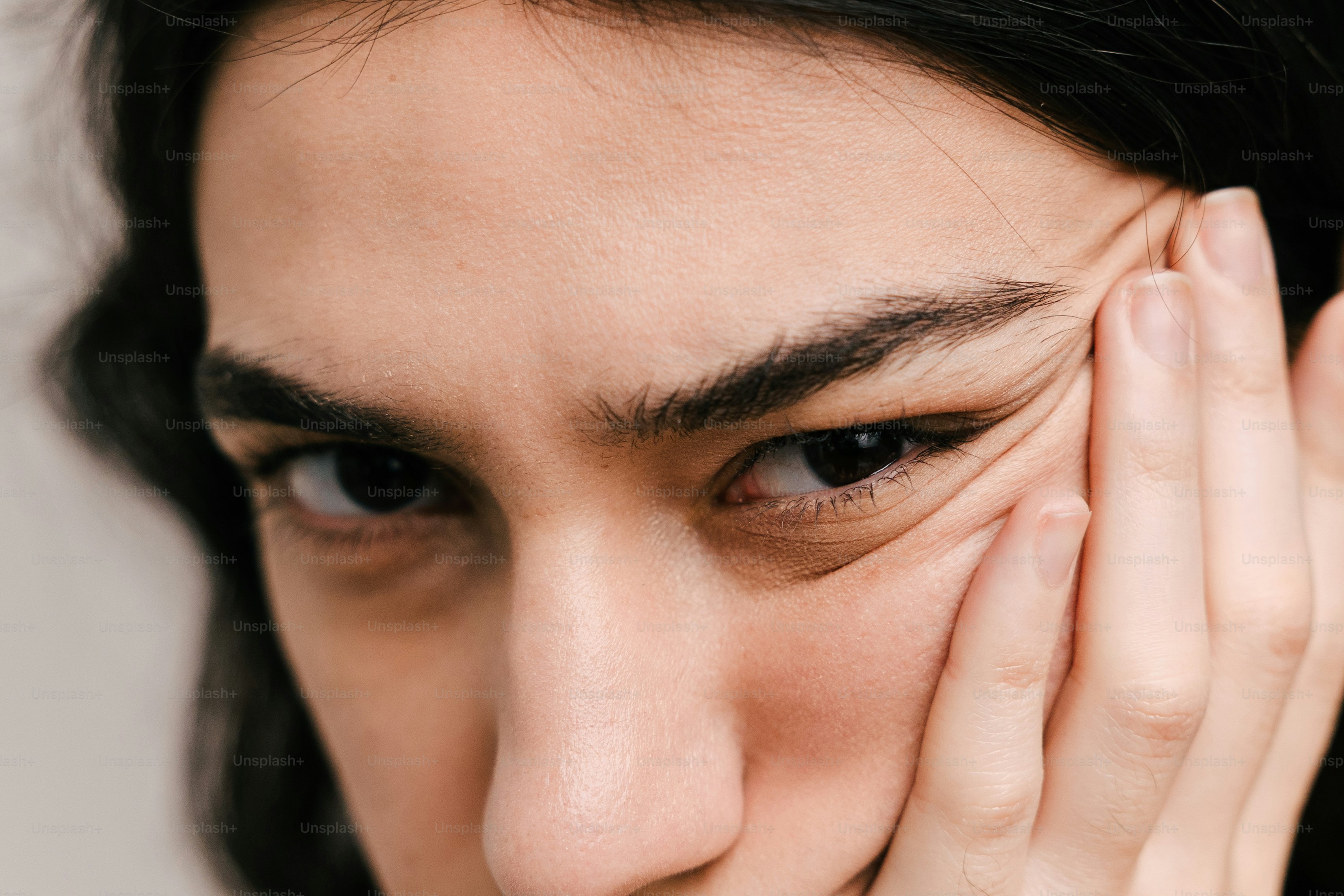 A close up of a person holding their hand to their face photo – Person ...