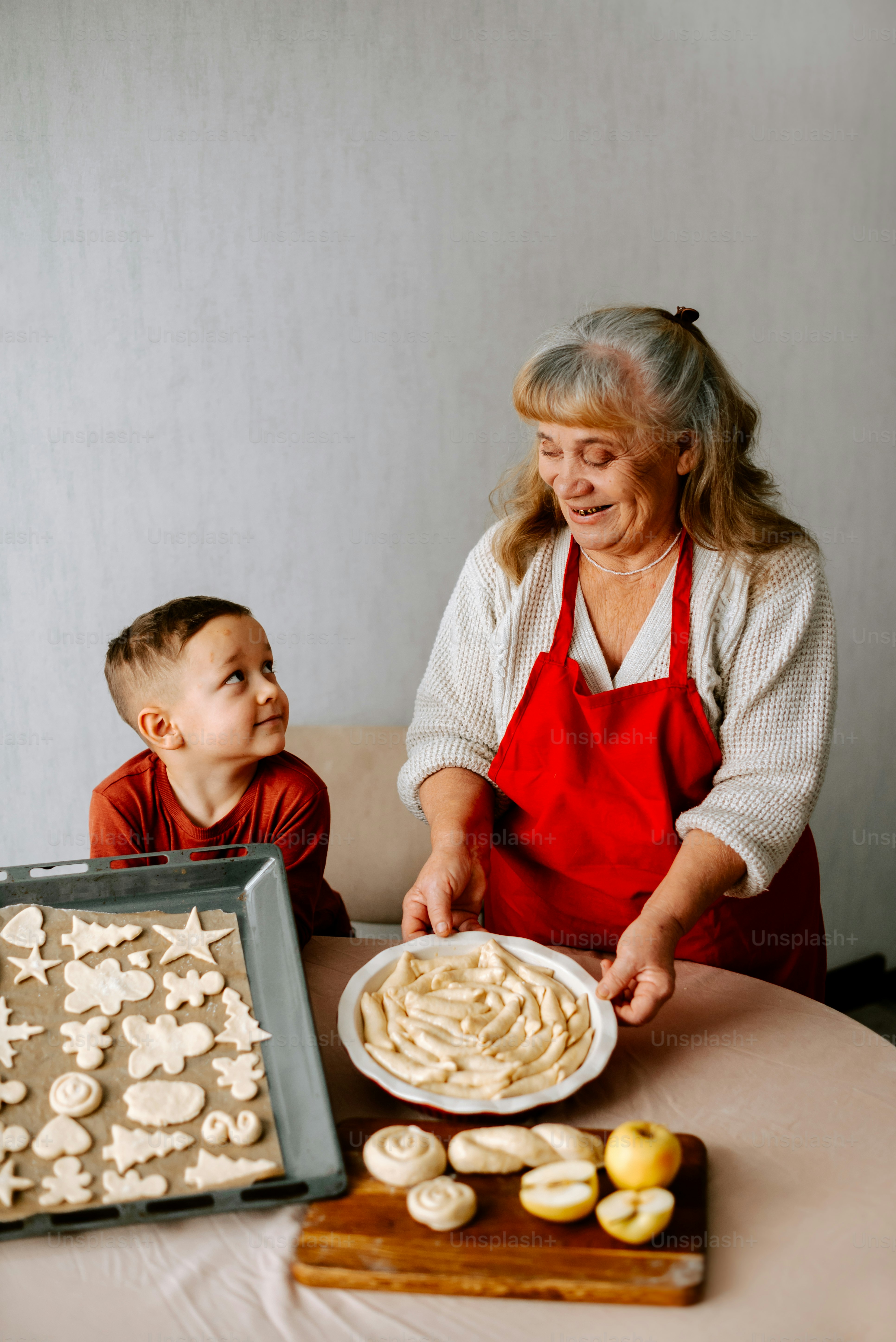 An older woman and a young boy making cookies photo – Cookies Image on ...