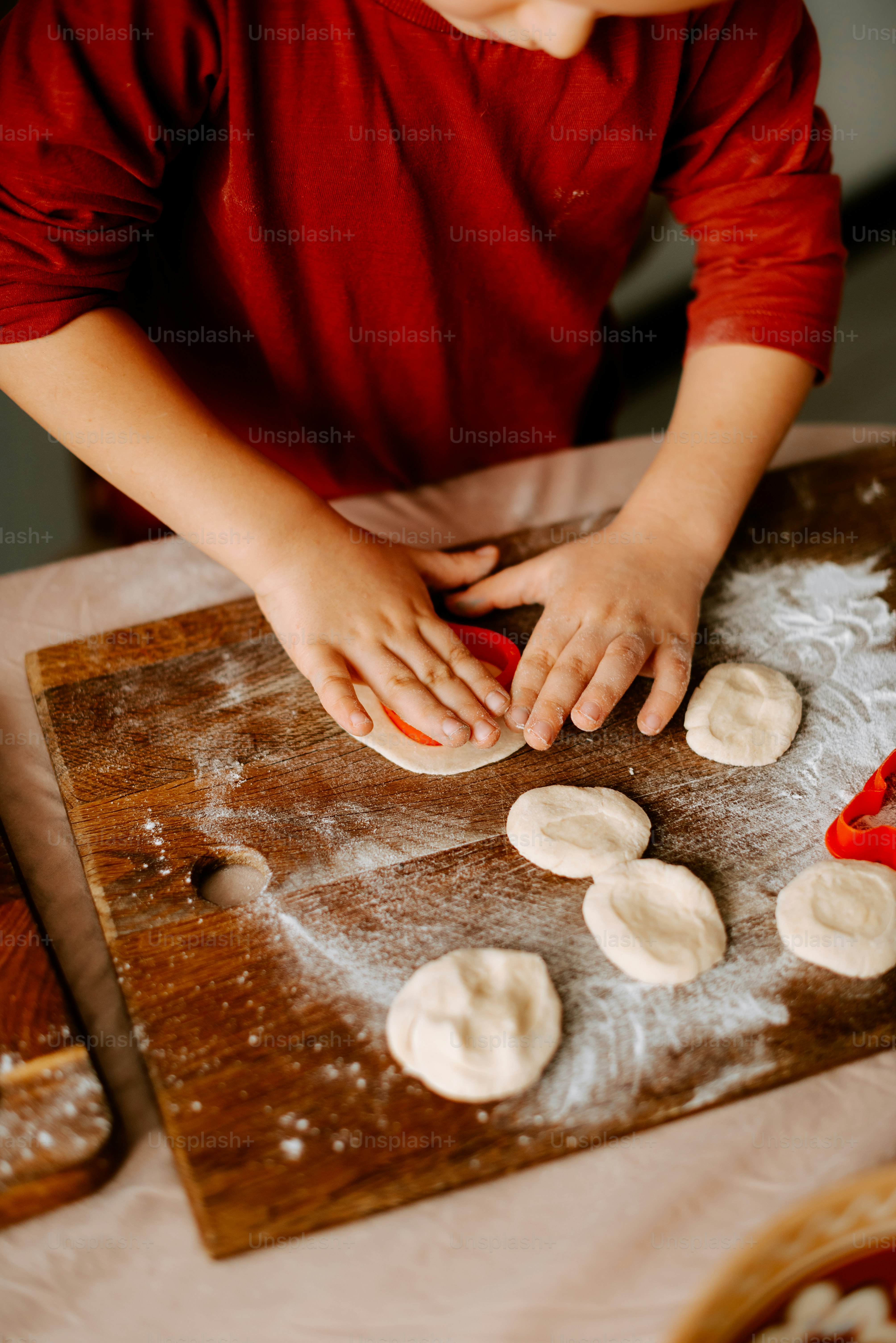 A child is making dough on a cutting board photo – People Image on Unsplash