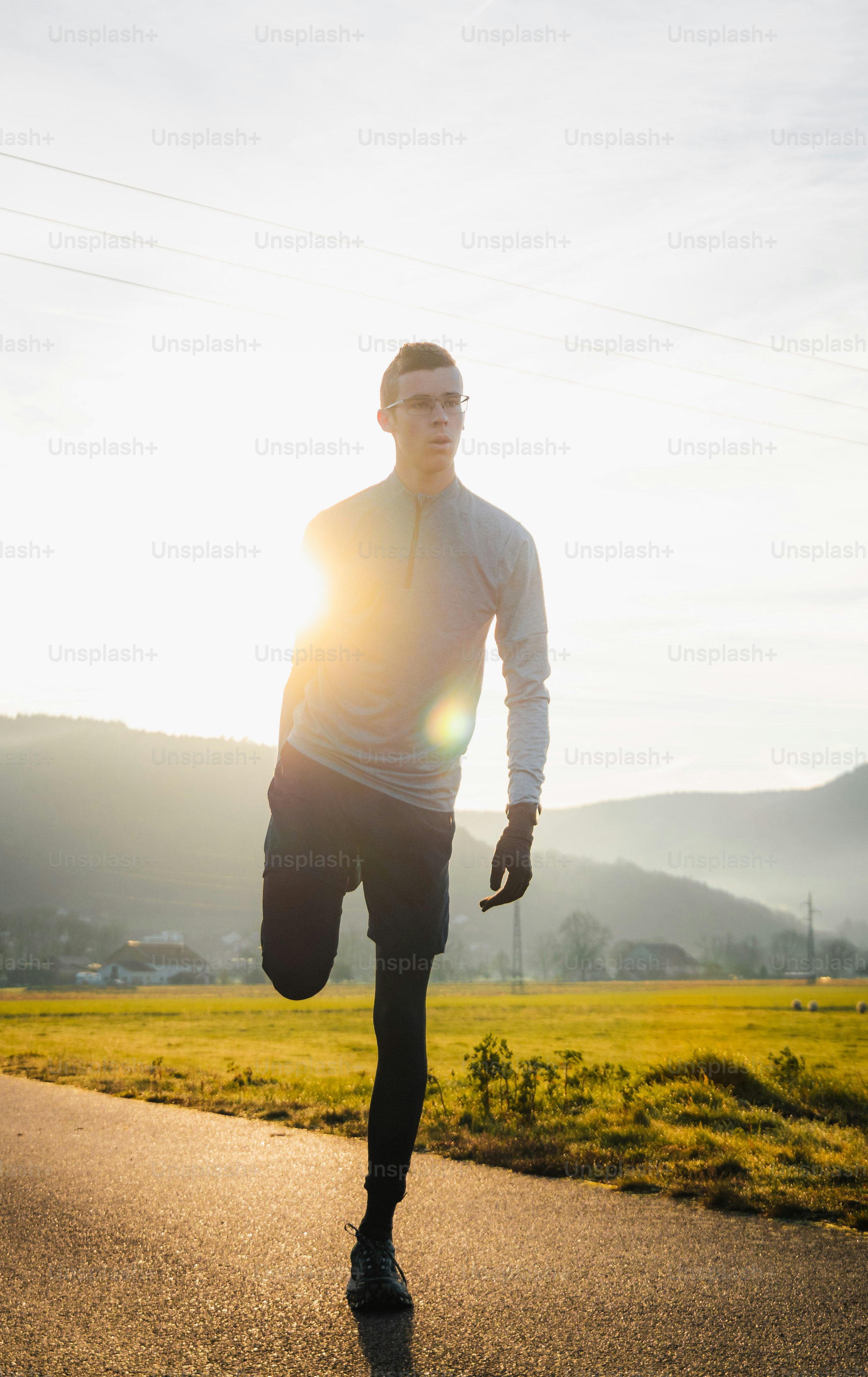 A person running down a road in the sun photo – Running Image on Unsplash