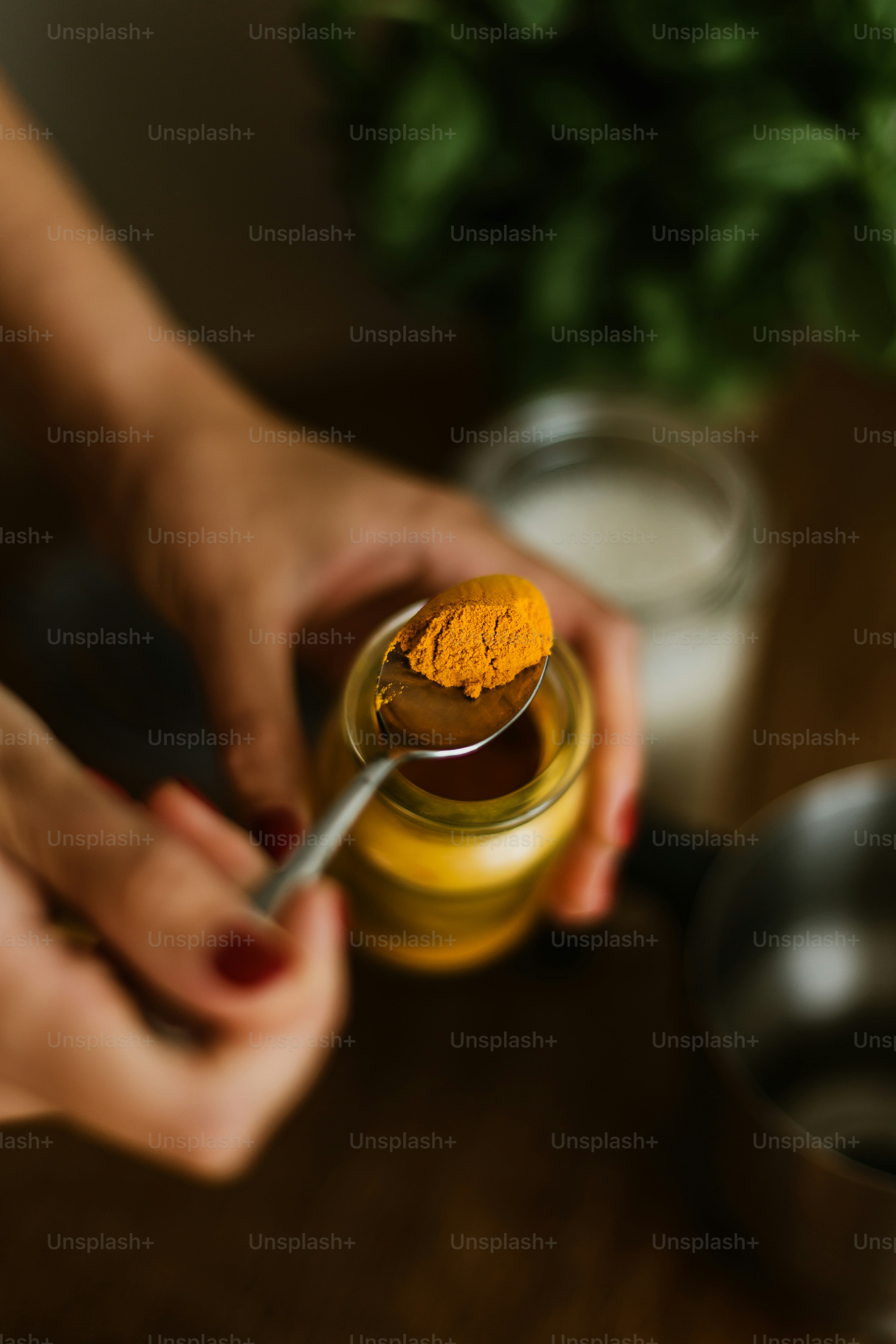 A person holding a spoon over a jar of mustard photo – Indian spice ...