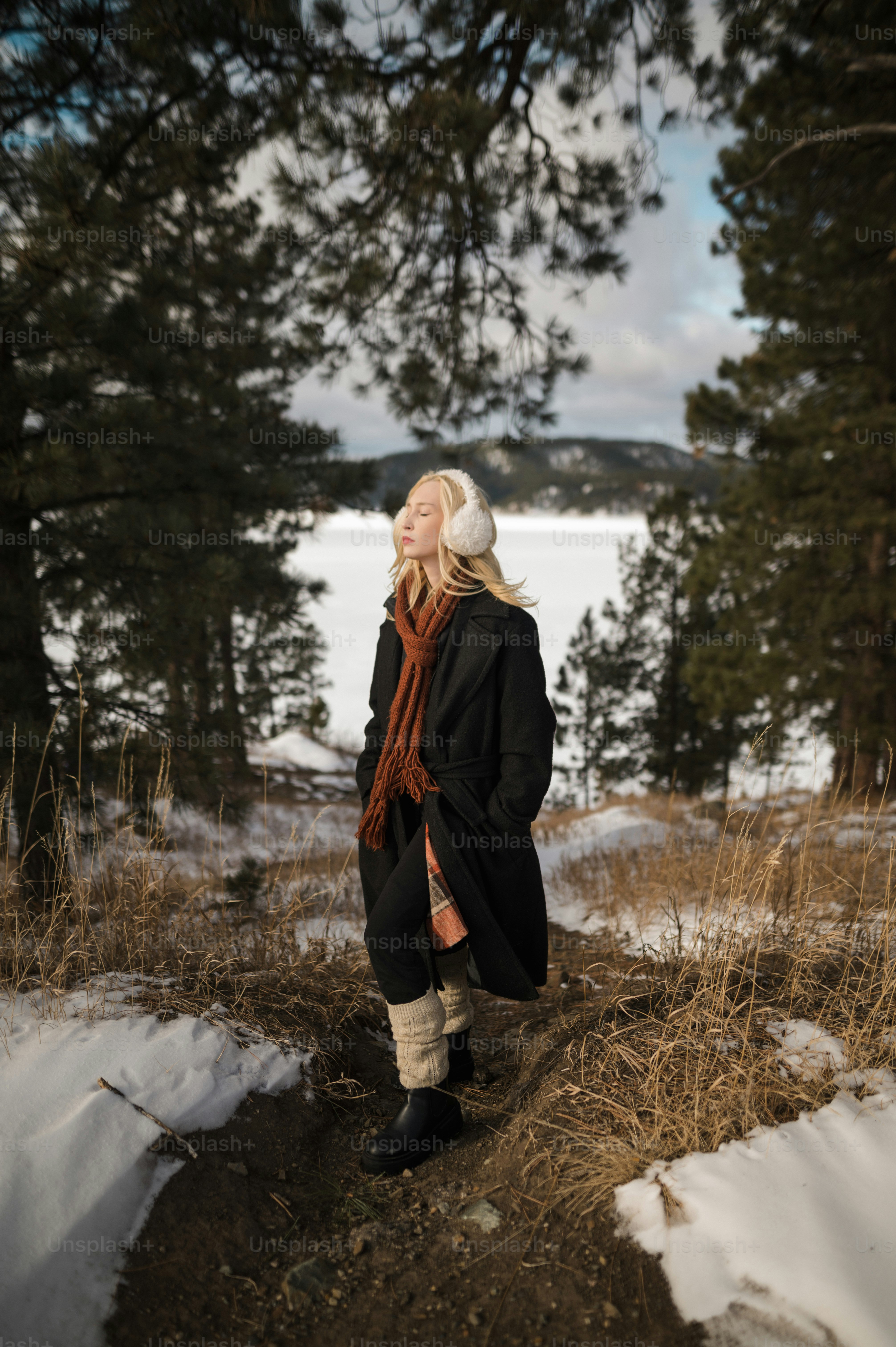 A woman standing in a field with snow on the ground photo – Nature girl ...