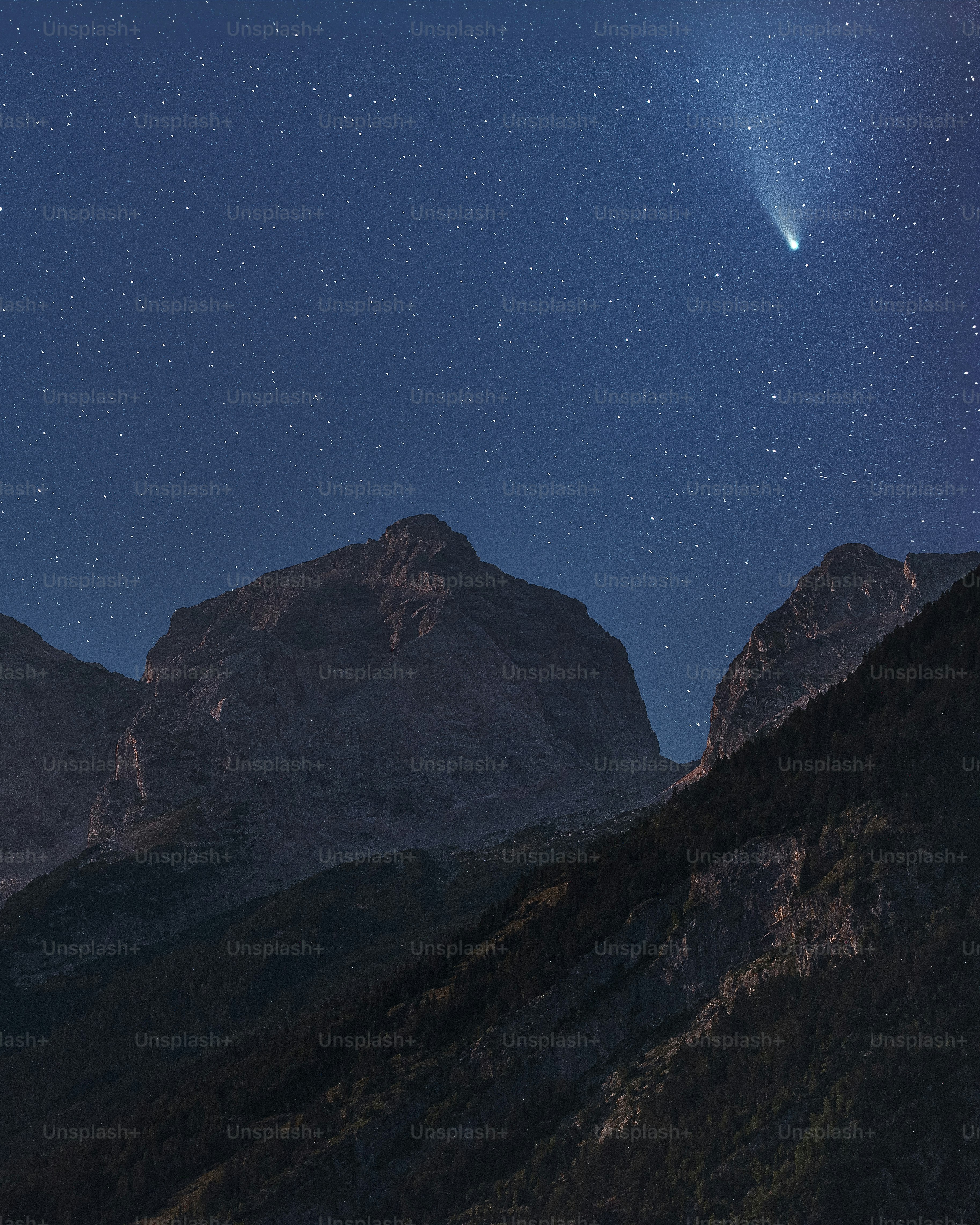 A view of a mountain with a bright star in the sky photo – Starry night ...