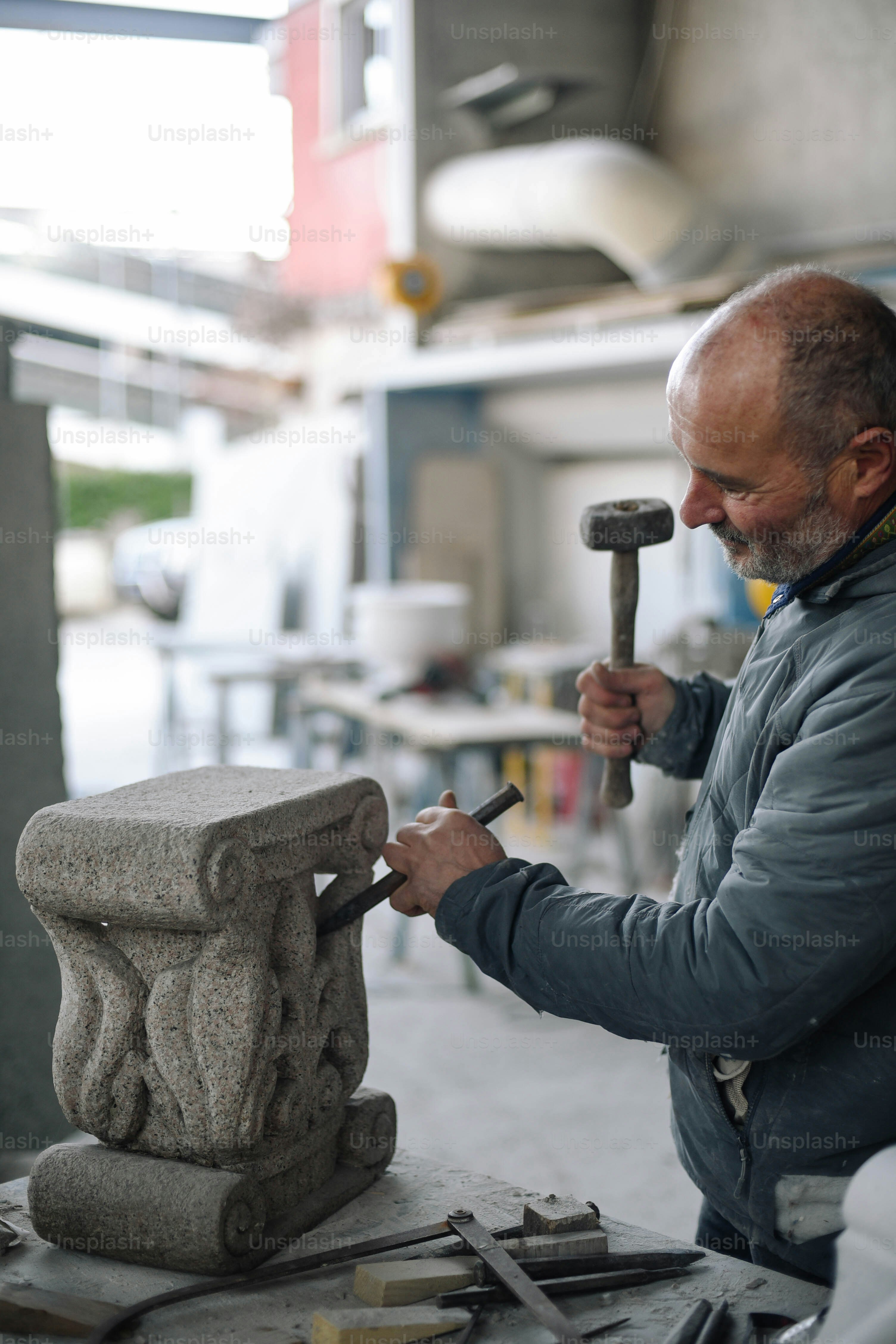 A man is working on a statue with a hammer photo – Hammer Image on Unsplash