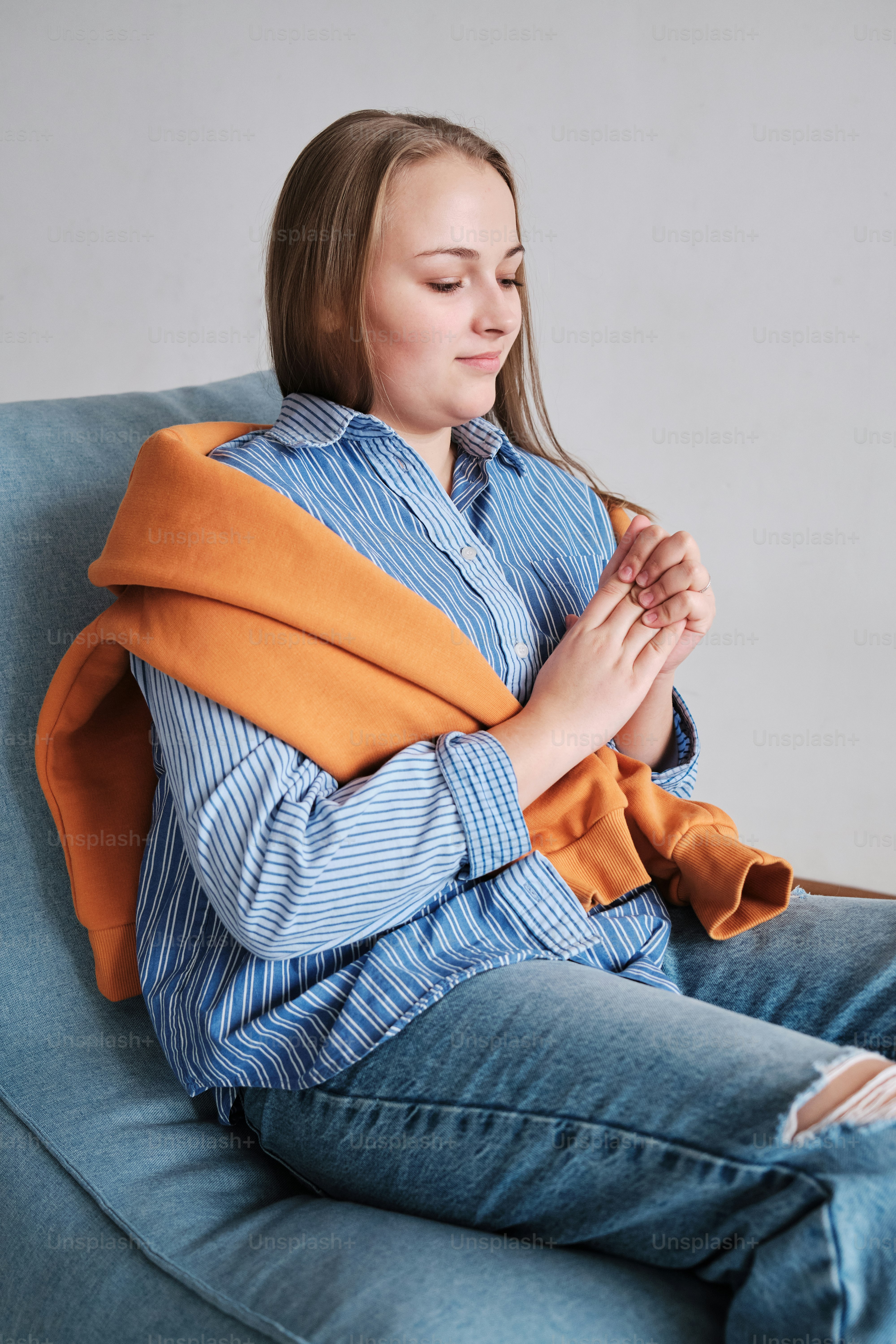 Foto Una mujer sentada en una silla azul con las manos cruzadas – Mujer ...