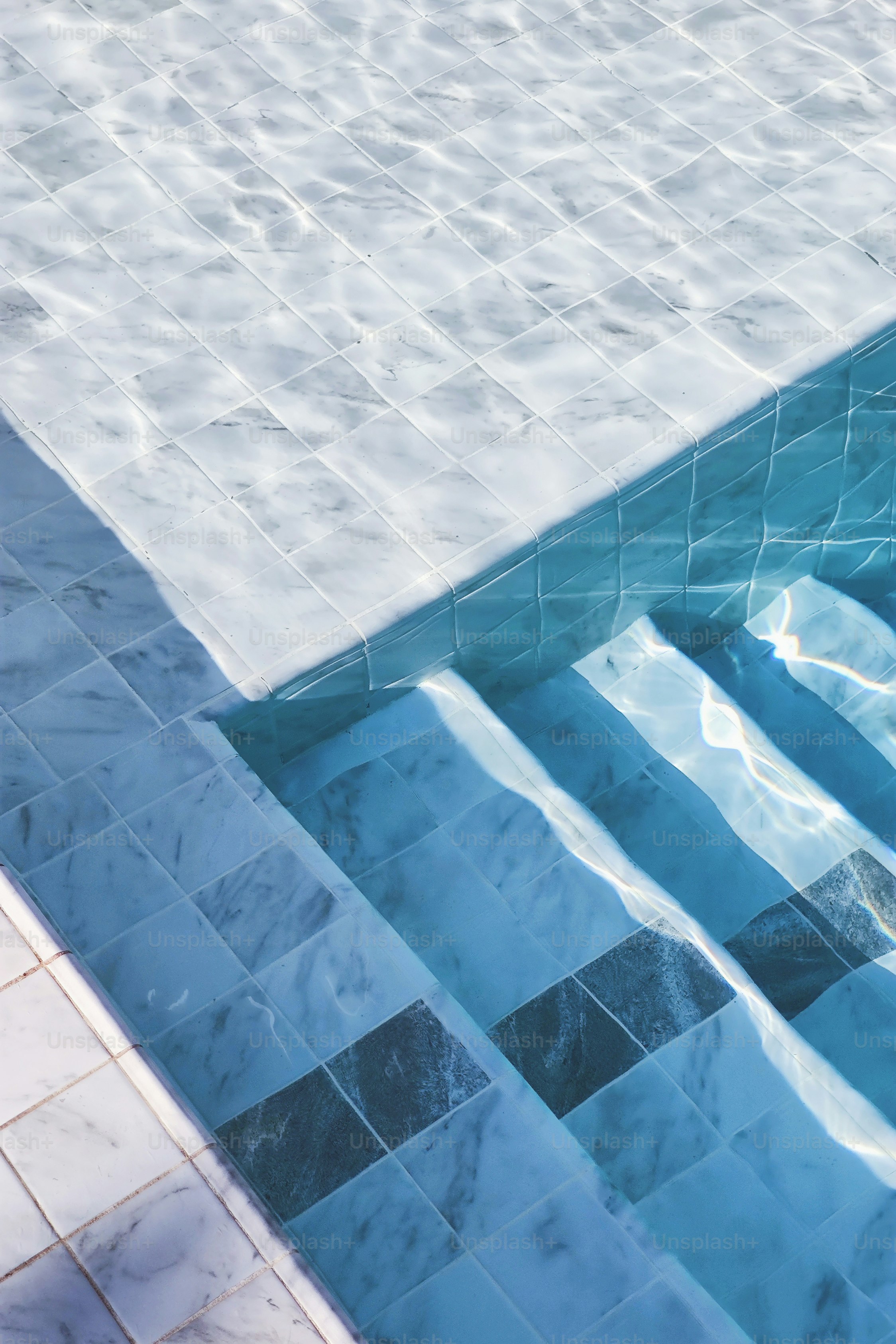 A tiled swimming pool with blue and white tiles photo – Water Image on ...