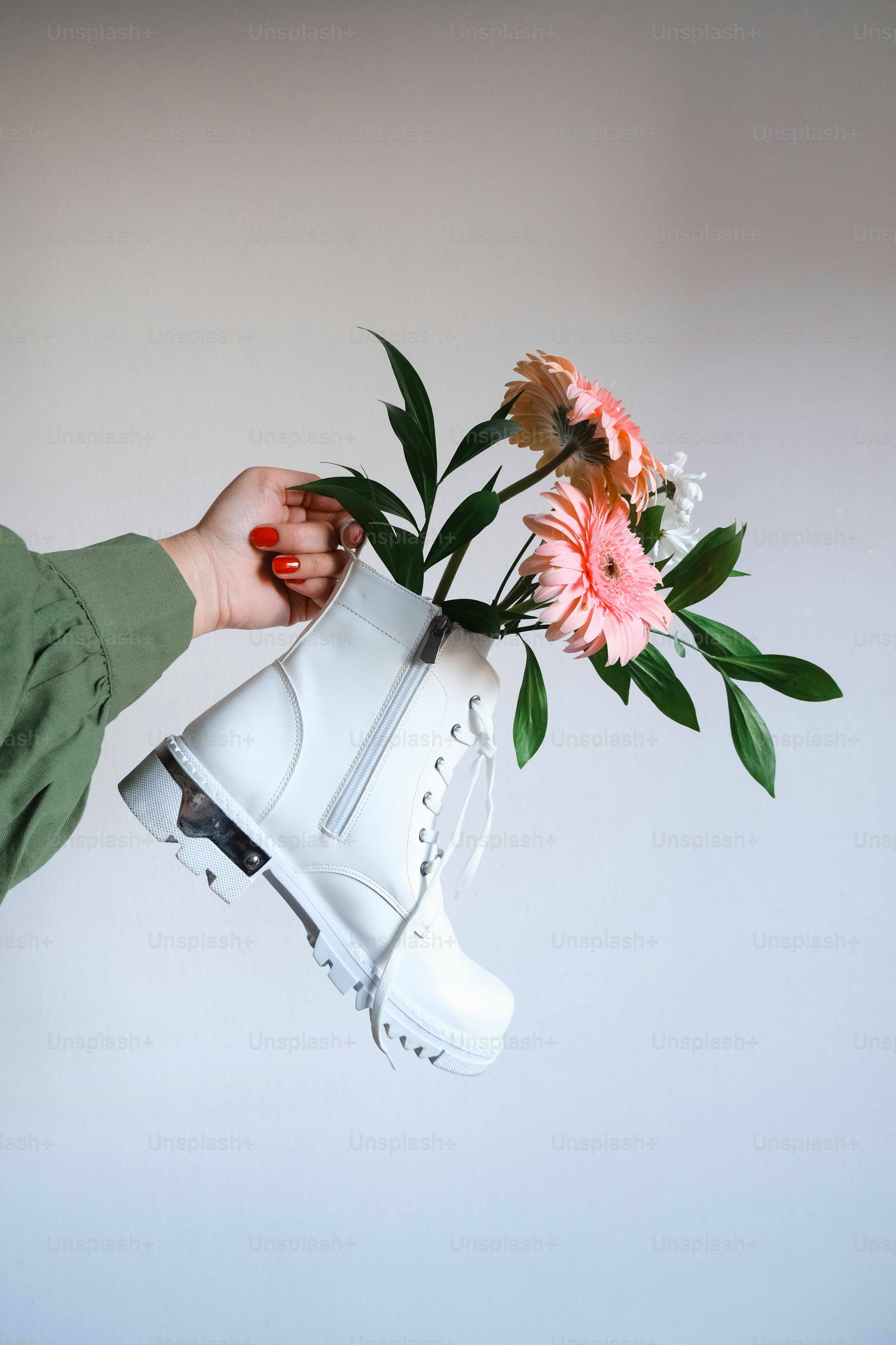 A person holding a white boot with flowers in it photo – Ankara Image ...