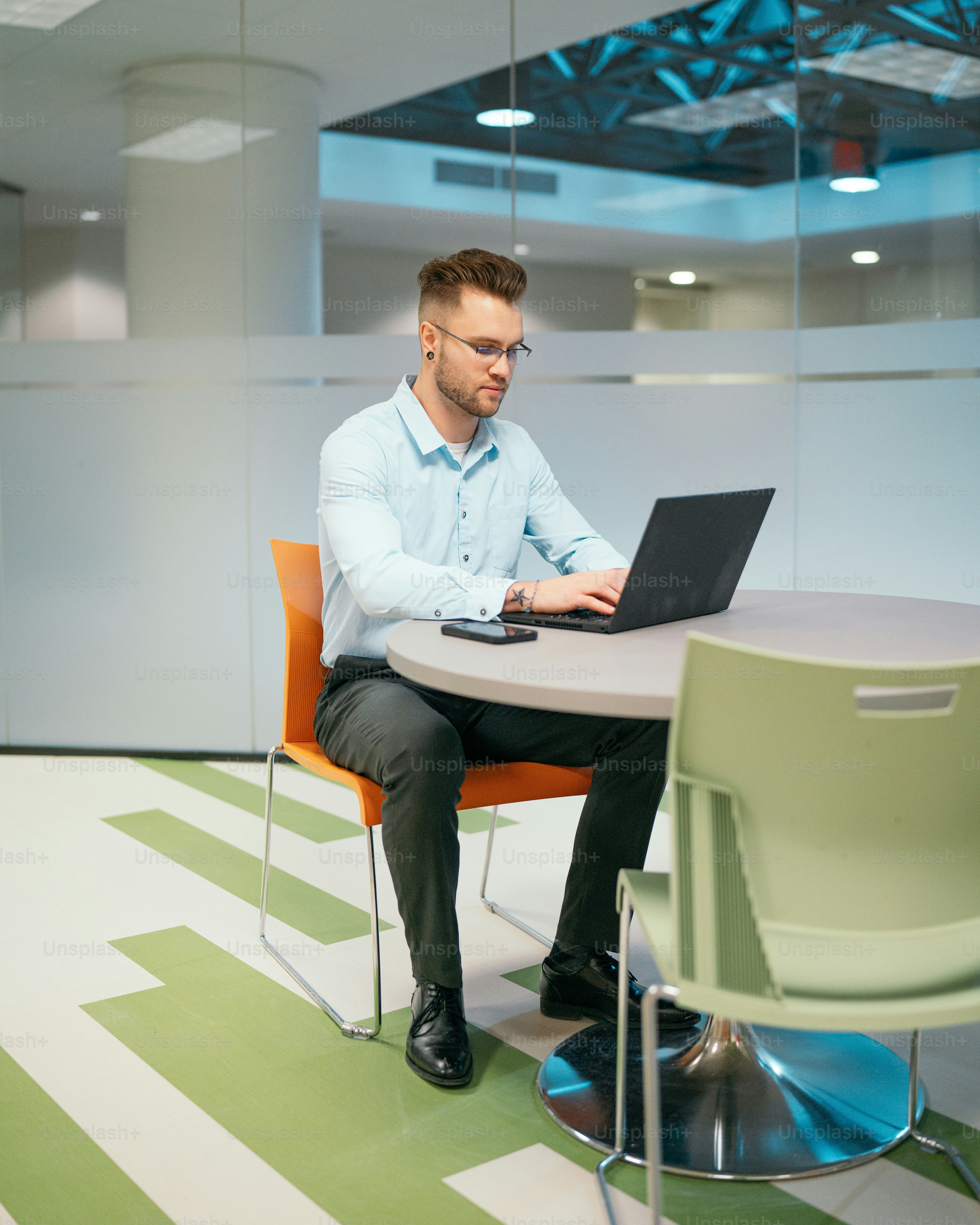 Un homme assis à une table avec un ordinateur portable photo – Masculin ...