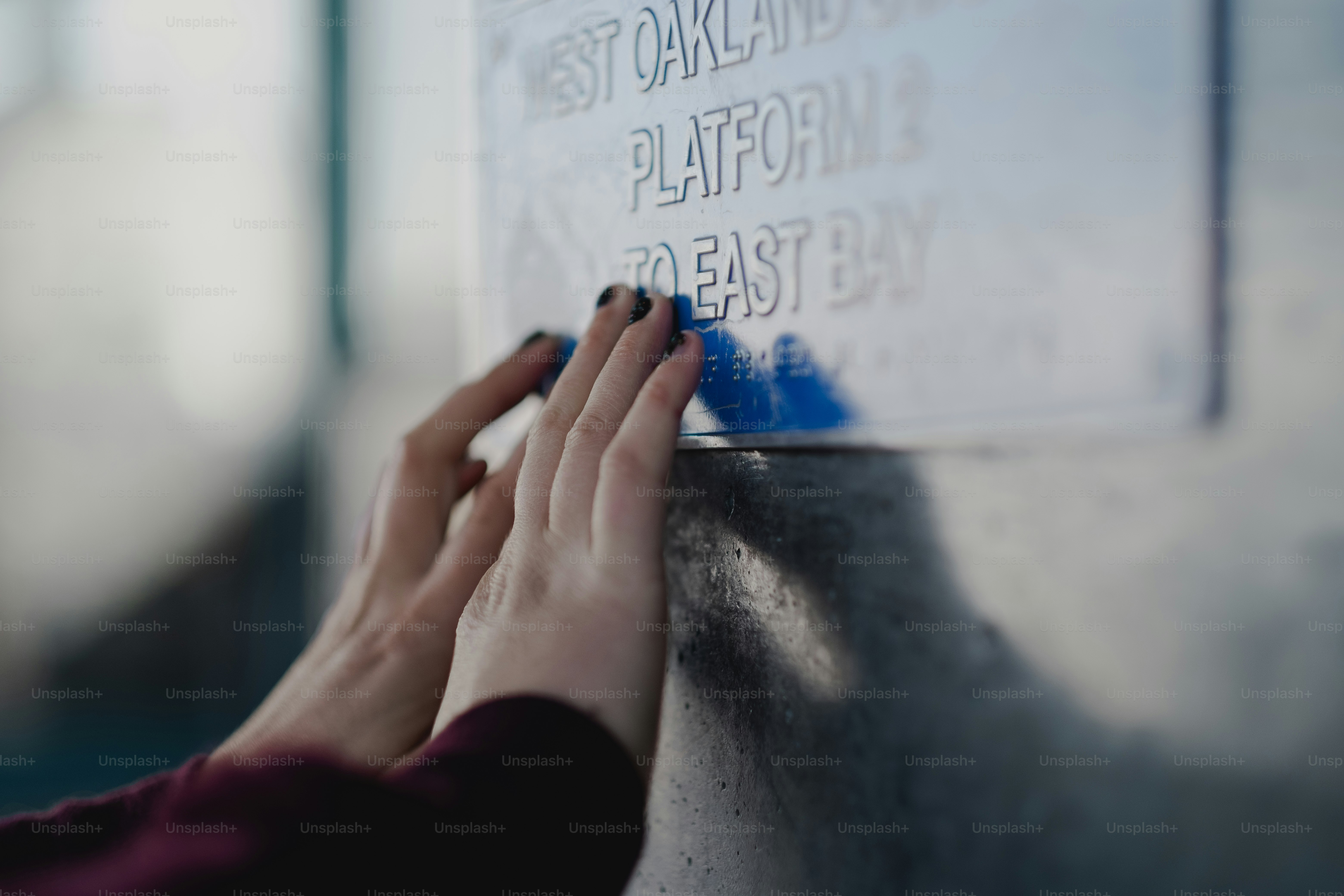 A person writing on a sign on a wall photo – Disability Image on Unsplash