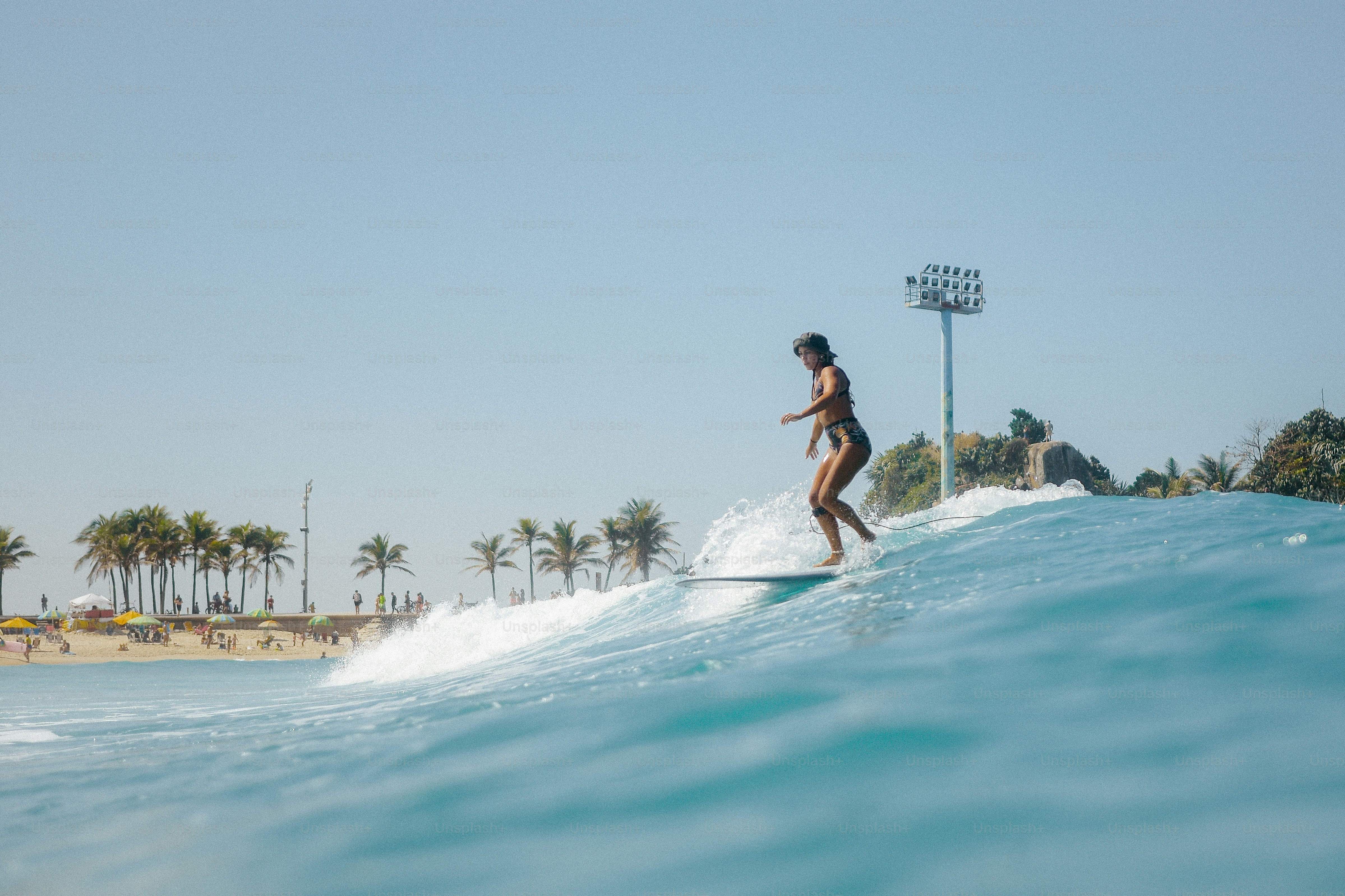 A woman riding a wave on top of a surfboard photo – Sky blue Image on ...