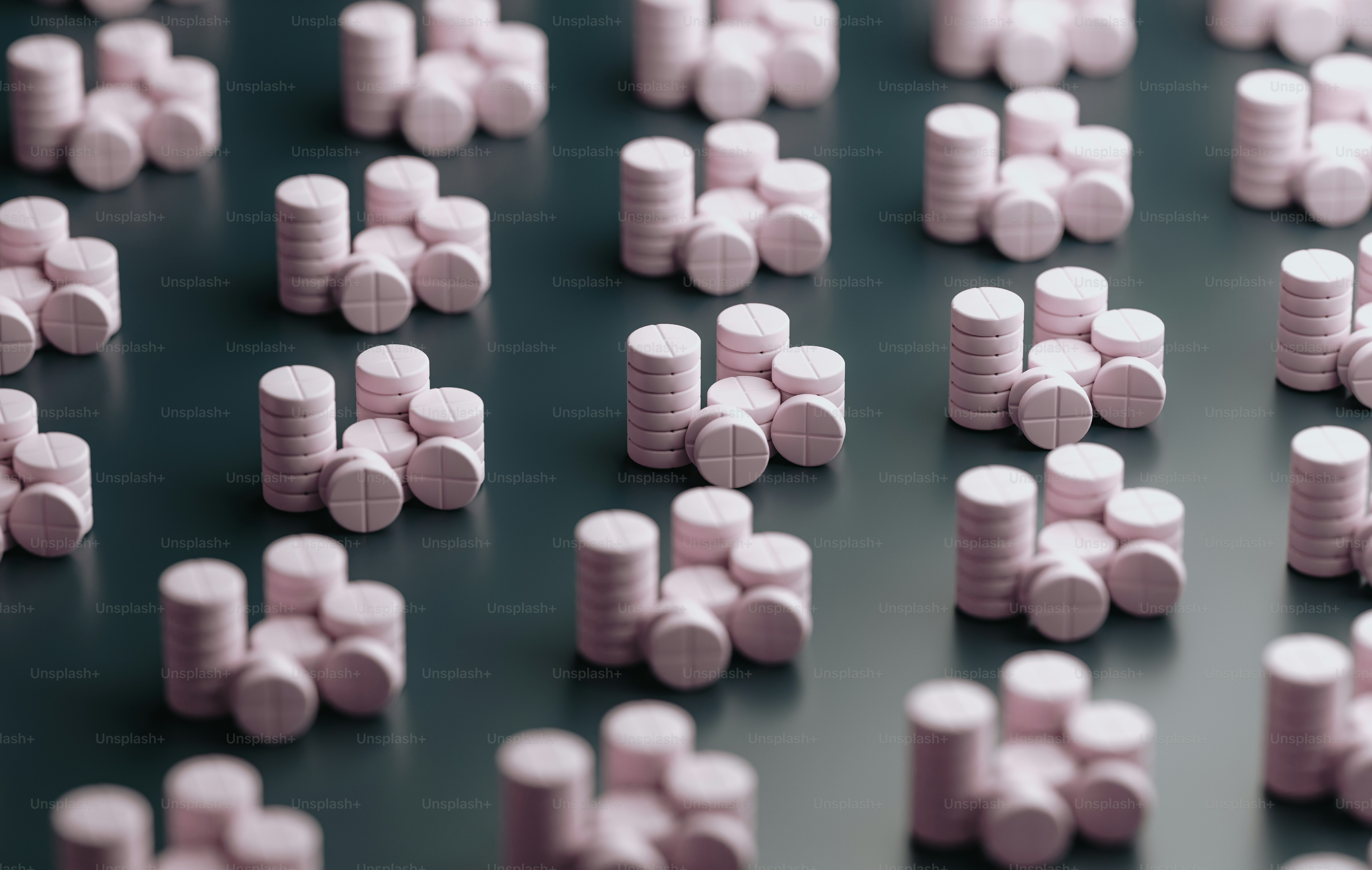 A large group of pink pills sitting on top of a table photo ...