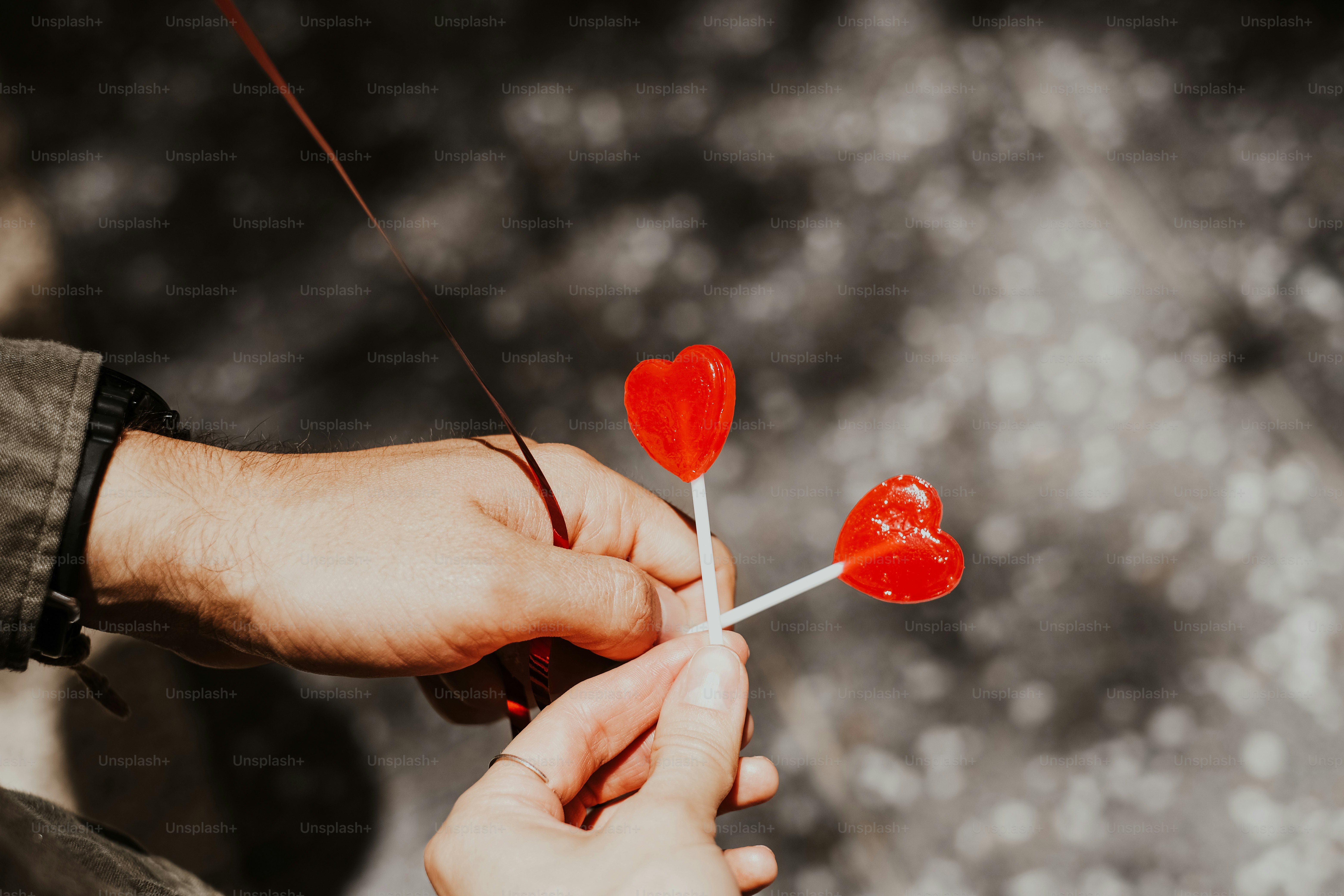 Una persona sosteniendo una piruleta con dos corazones en ella foto ...