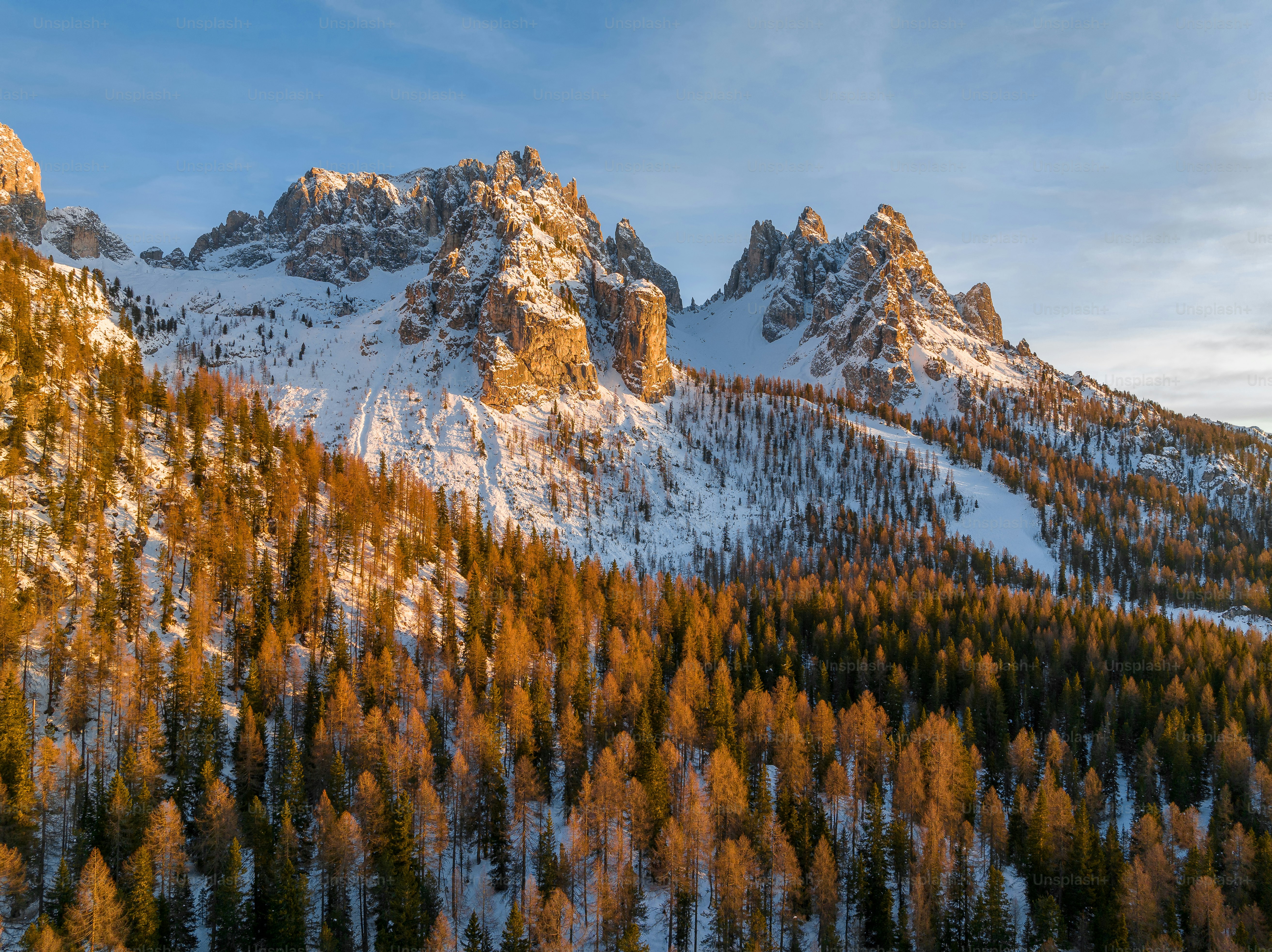 A snow covered mountain with trees in the foreground photo – Abyss ...