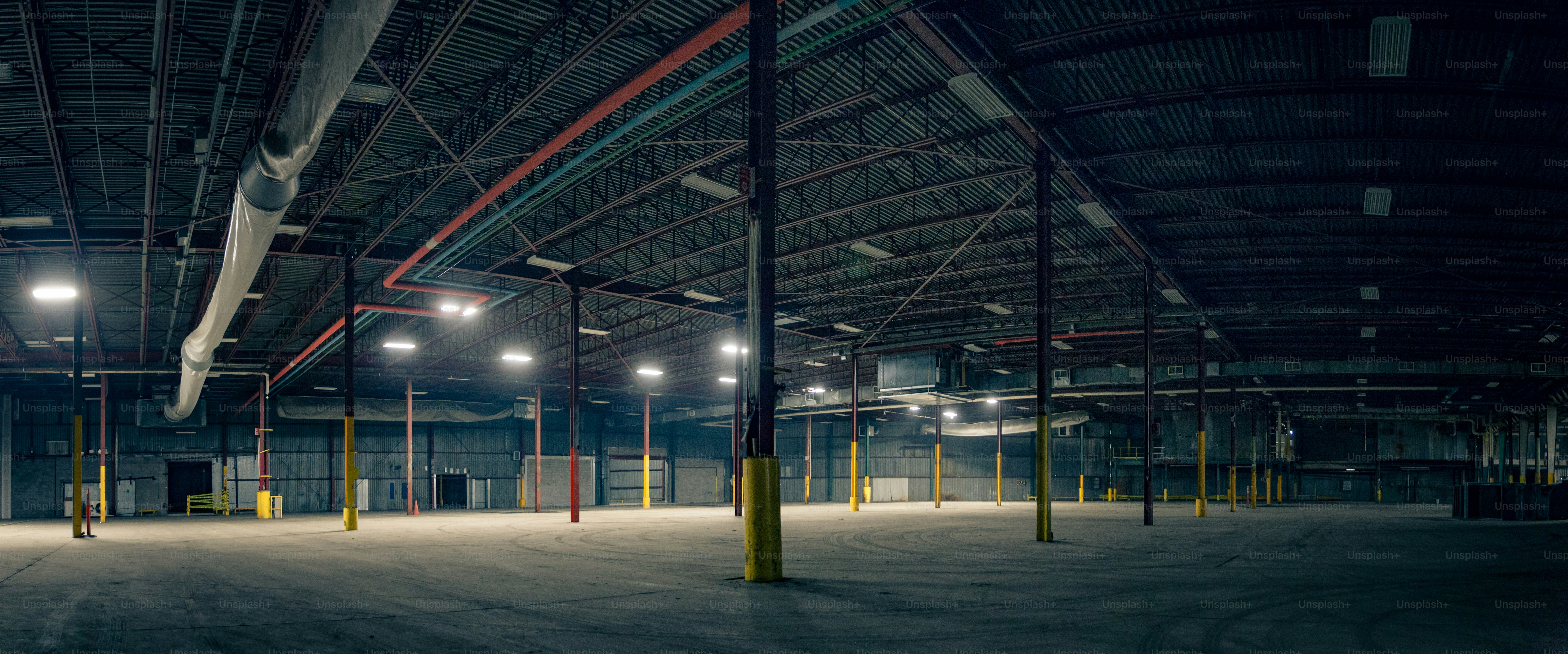 An empty warehouse with lights on the ceiling photo – Factory Image on ...