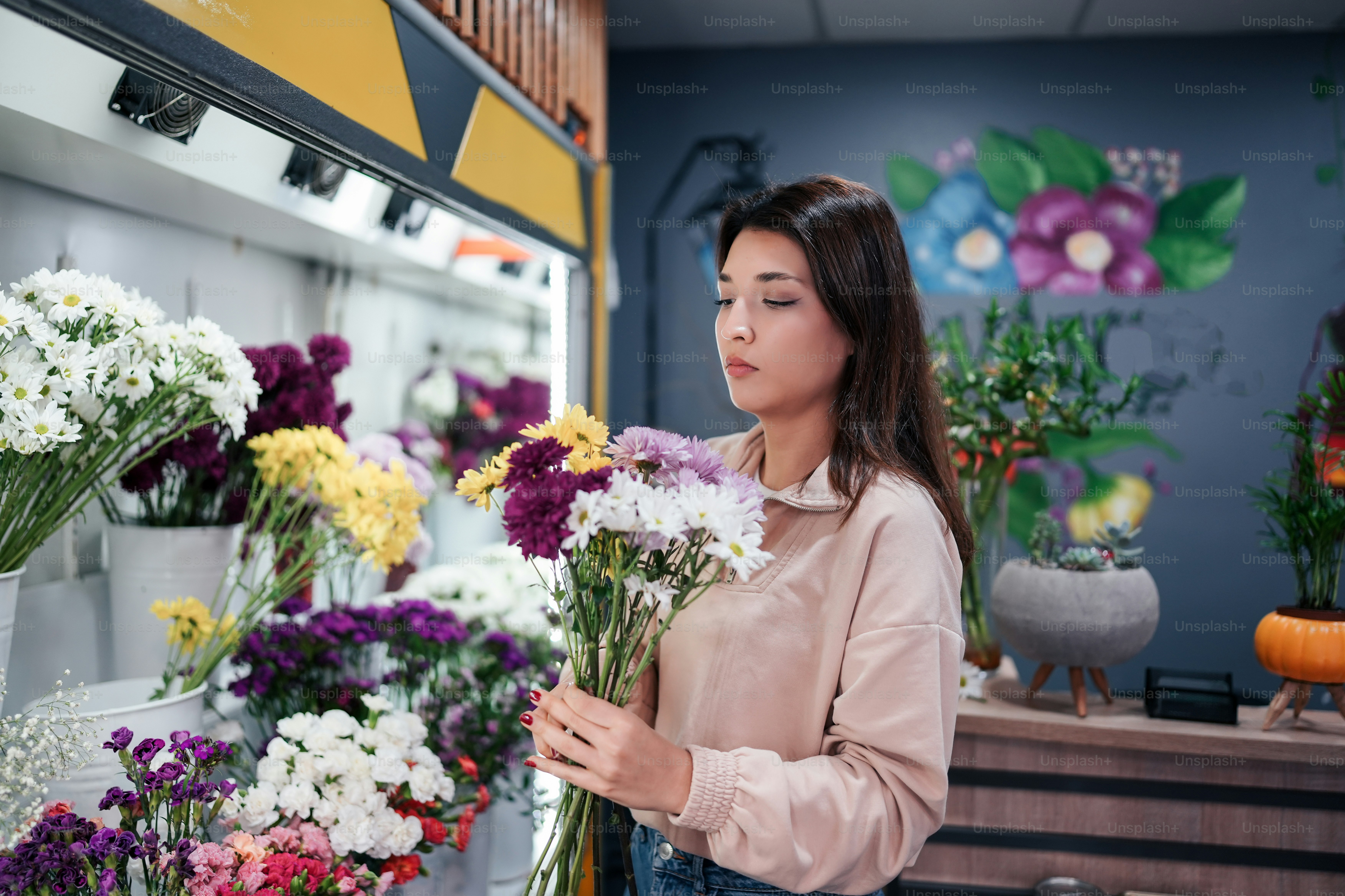A woman arranging flowers in a flower shop photo – Woman flowers Image ...