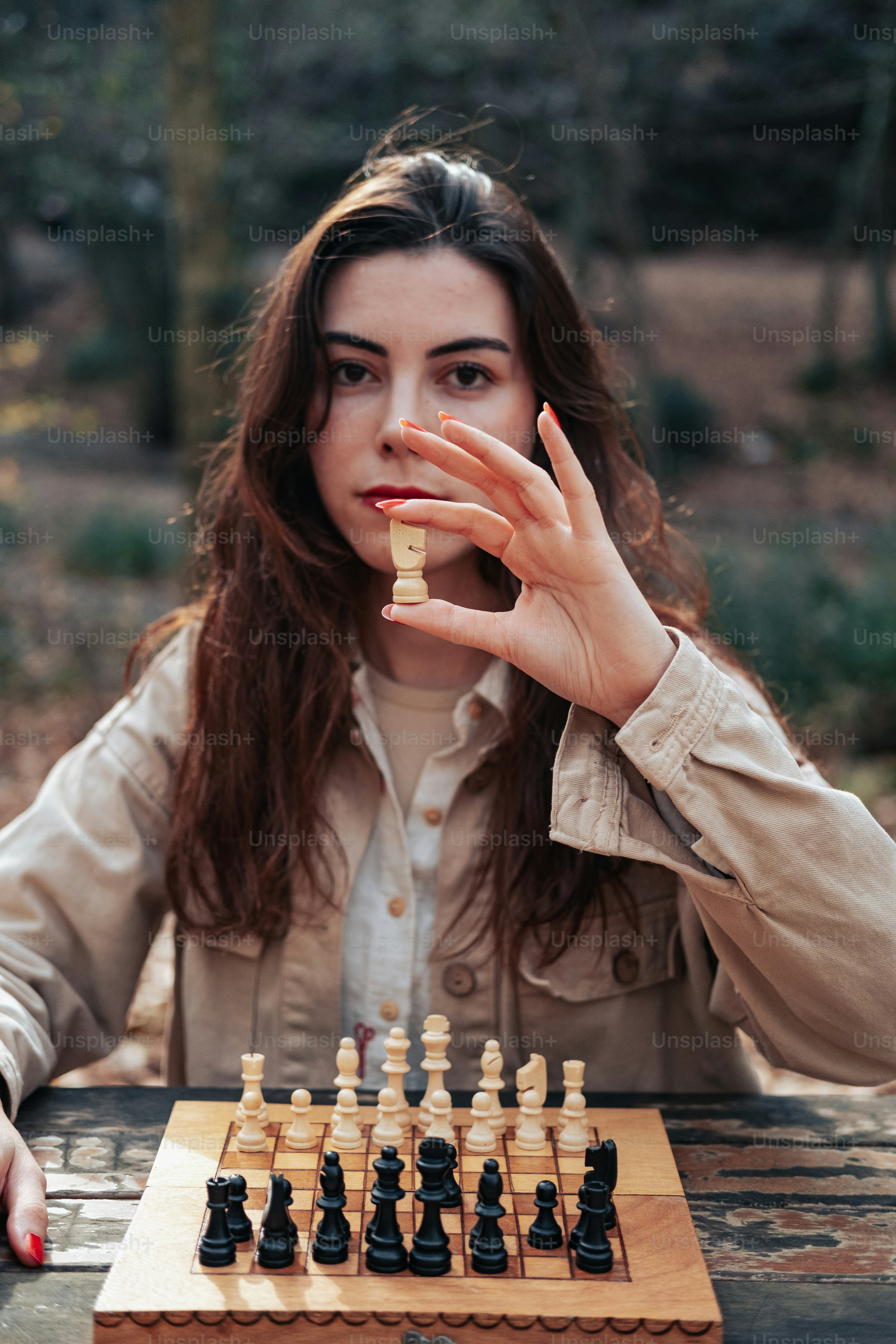 A woman sitting at a table with a chess board photo – Woman Image on Unsplash