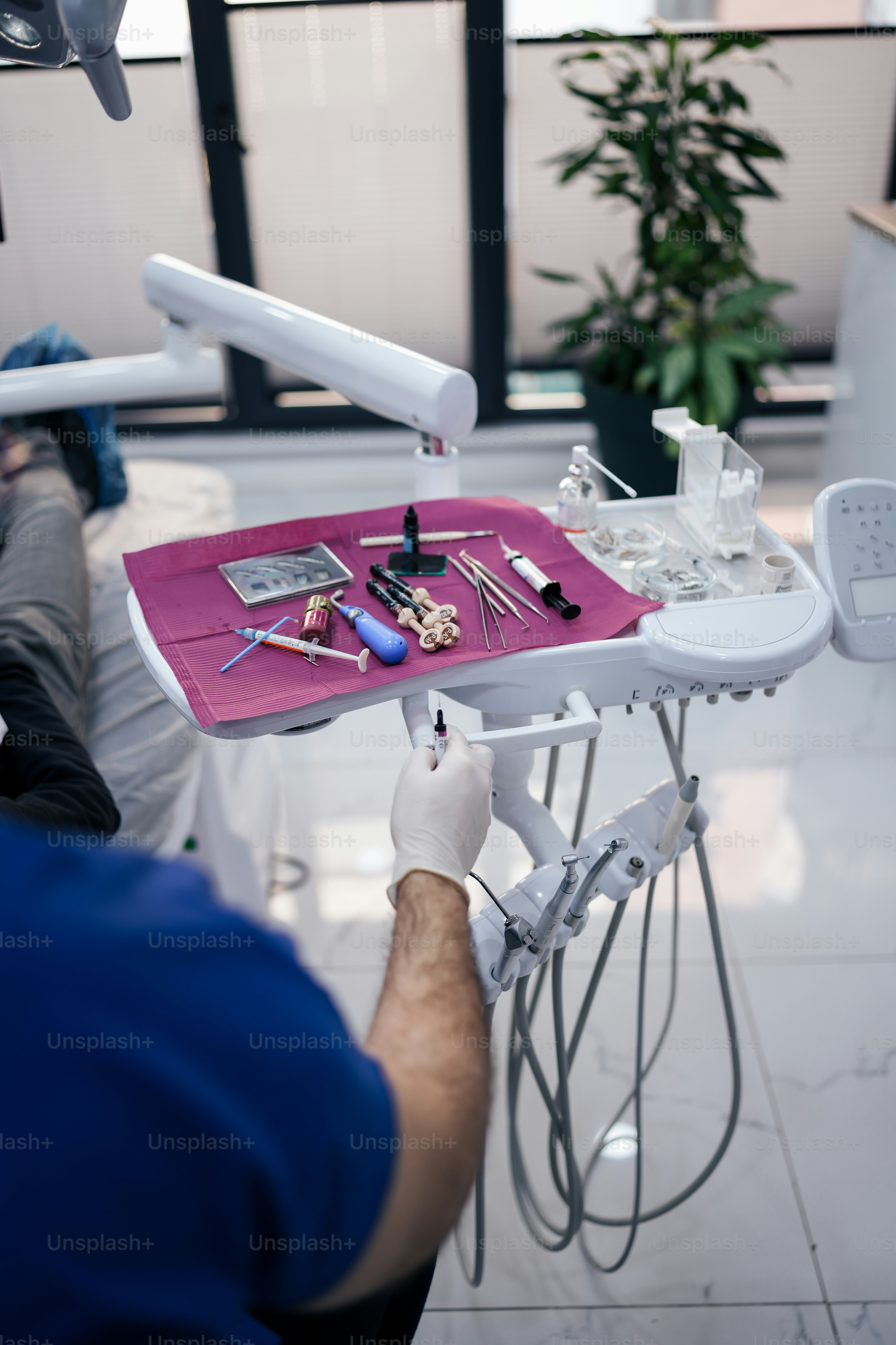 A man is sitting in a dentist chair with tools on it photo – Dental ...