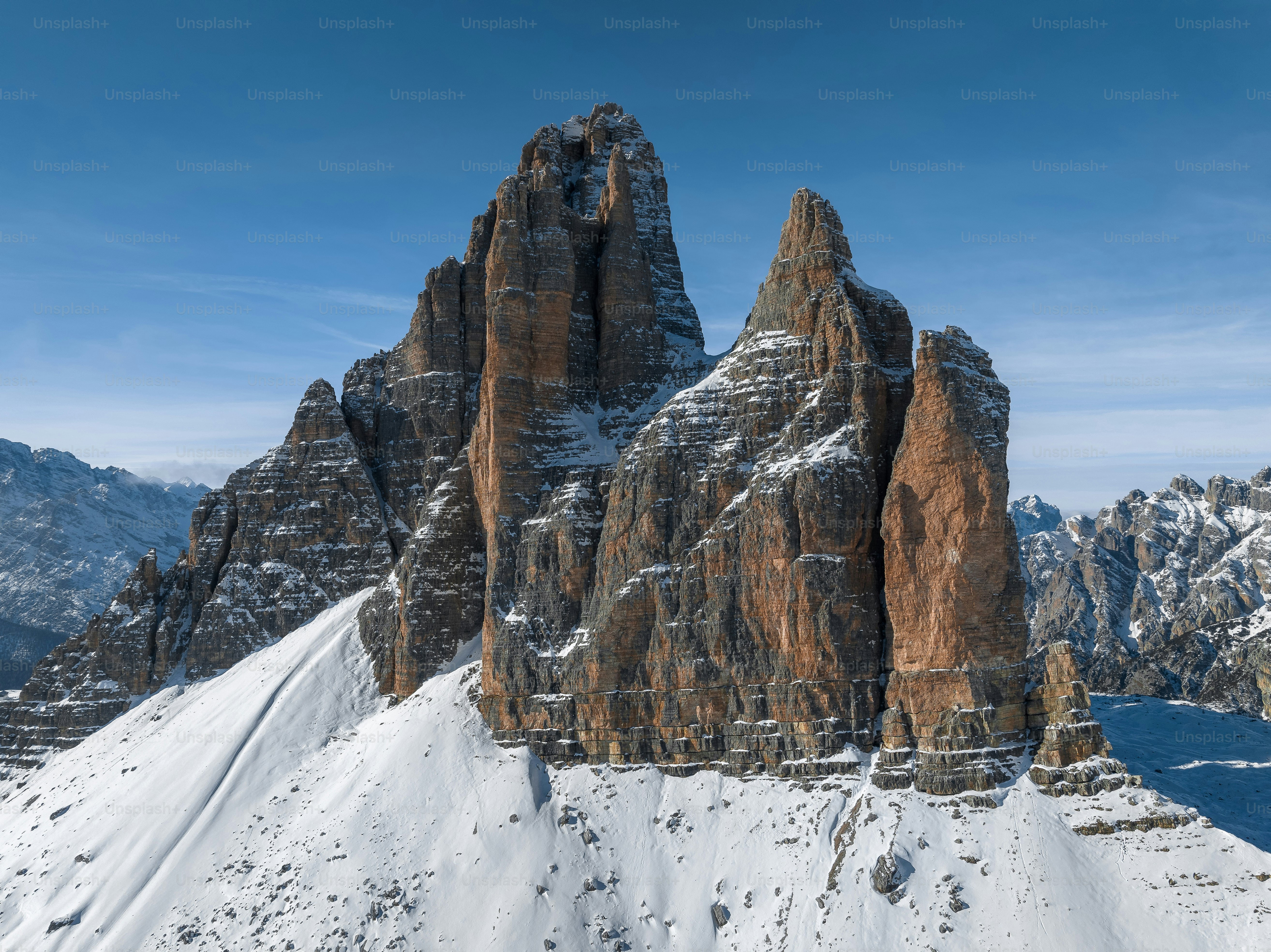 A mountain range covered in snow under a blue sky photo – Abyss Image ...