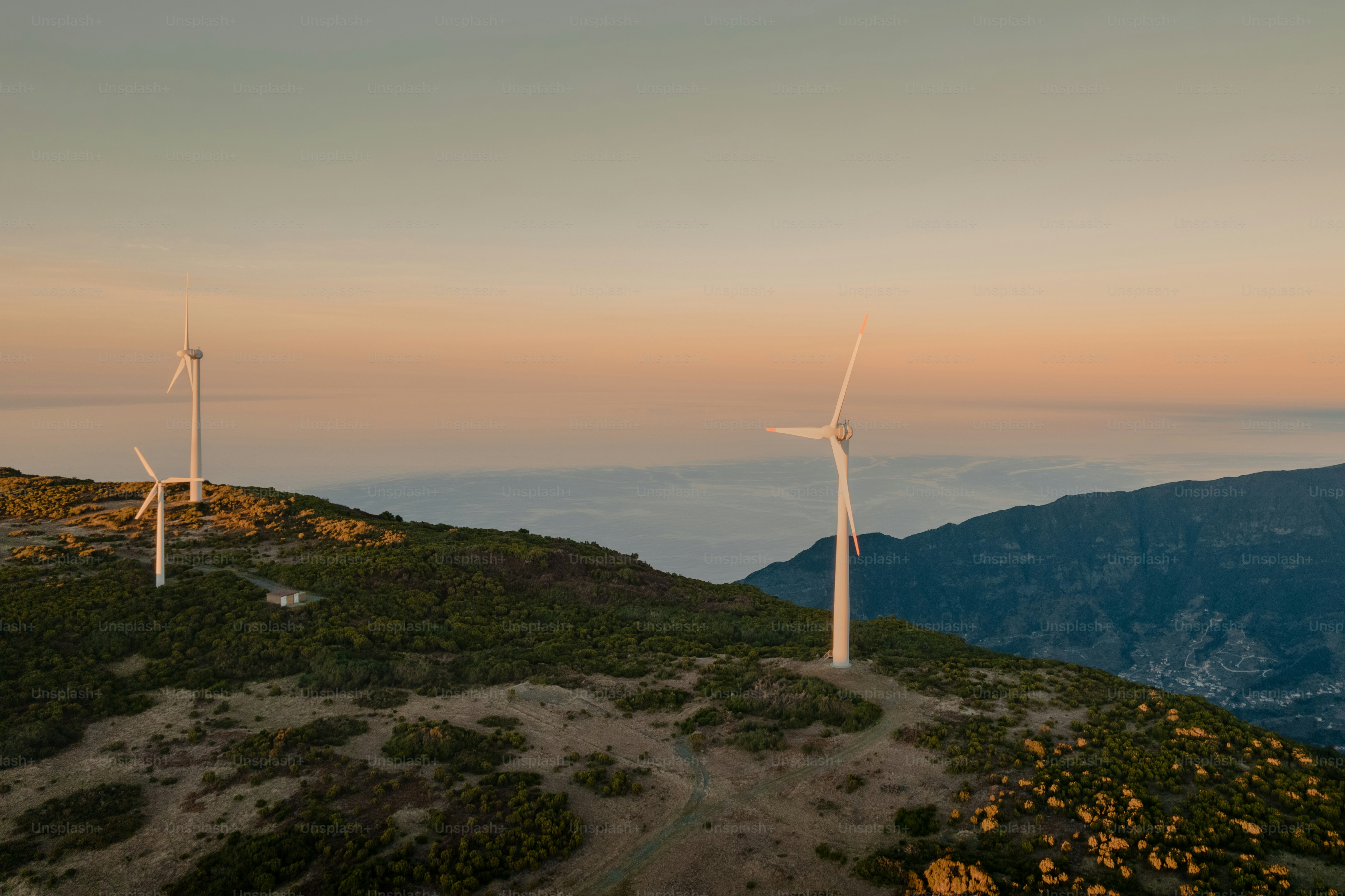 A couple of windmills on top of a hill photo – Breeze Image on Unsplash