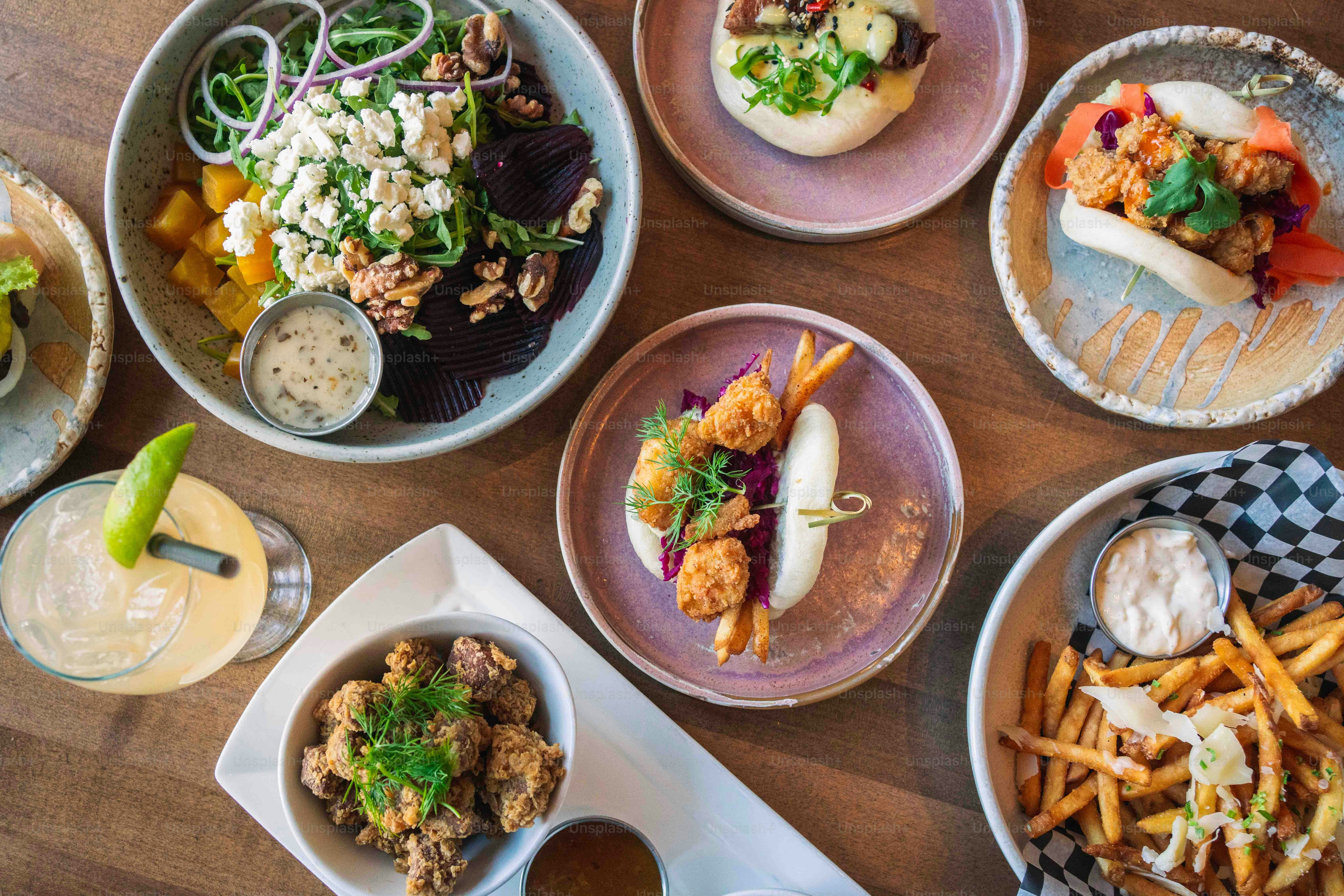 A table topped with plates of food and drinks photo – Dinner Image on ...