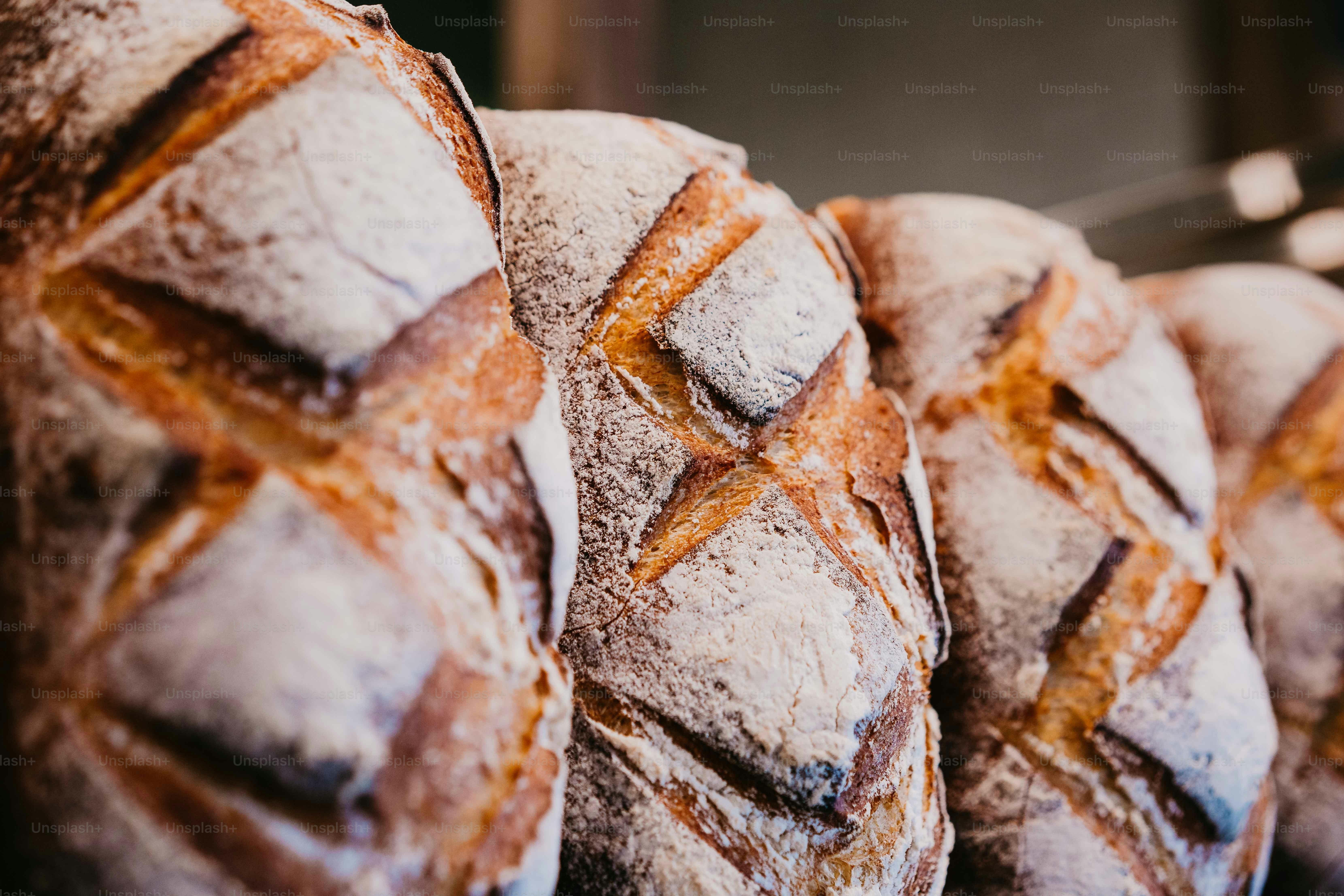 A row of loaves of bread sitting on top of a counter photo – Bakery ...