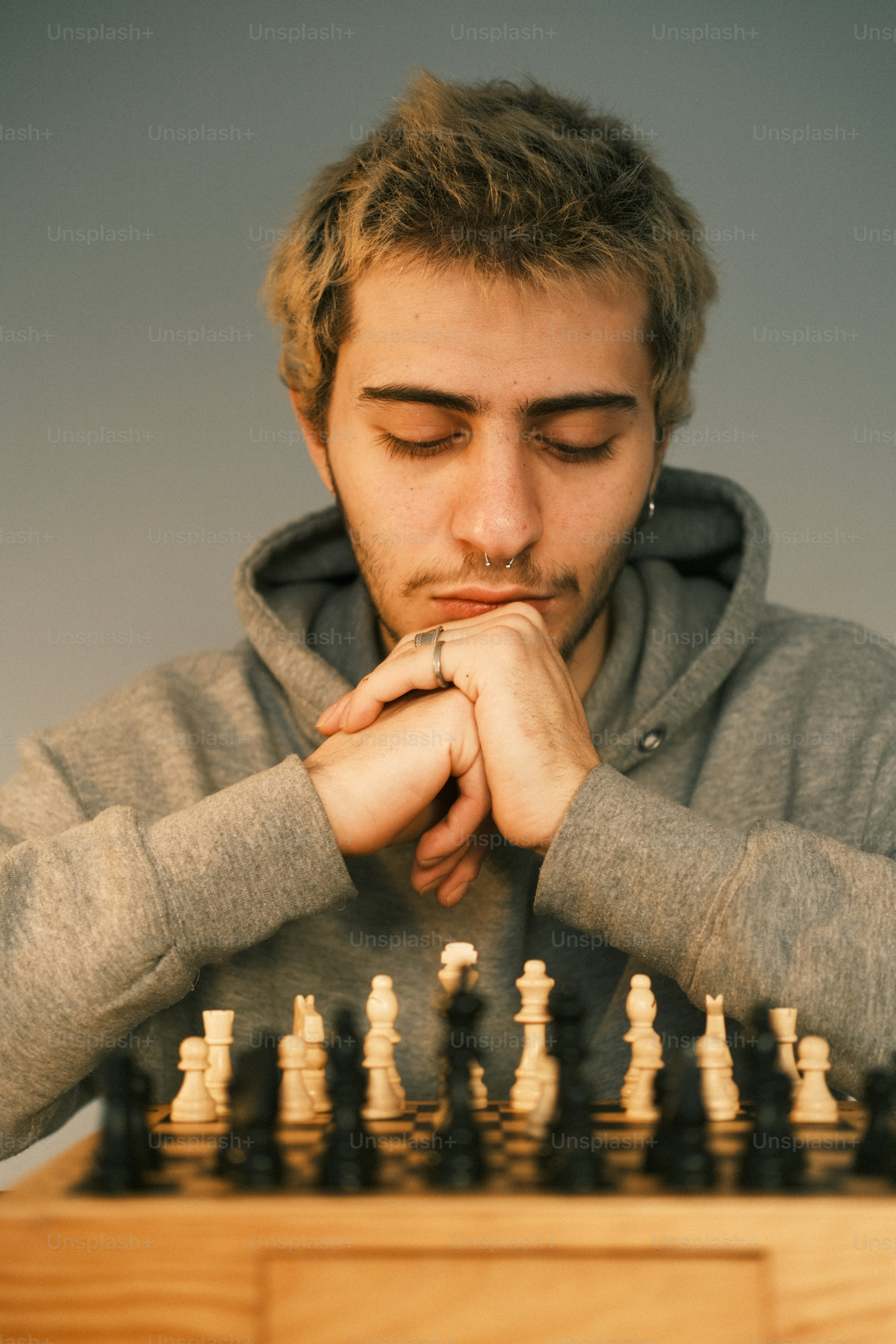 A man sitting at a table with a chess board photo – Chess player Image ...