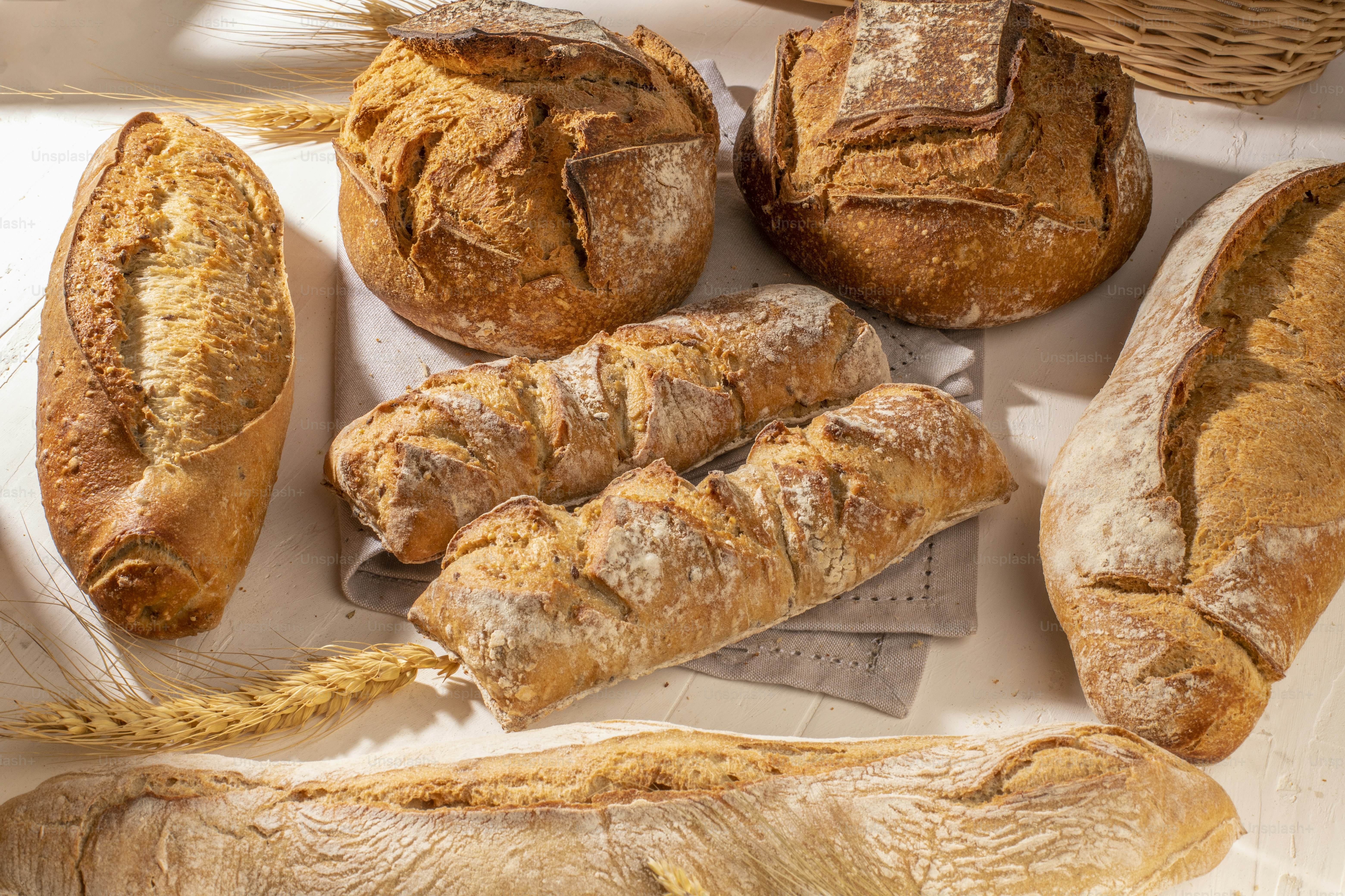 A table topped with loaves of bread and loaves of bread photo – Food ...