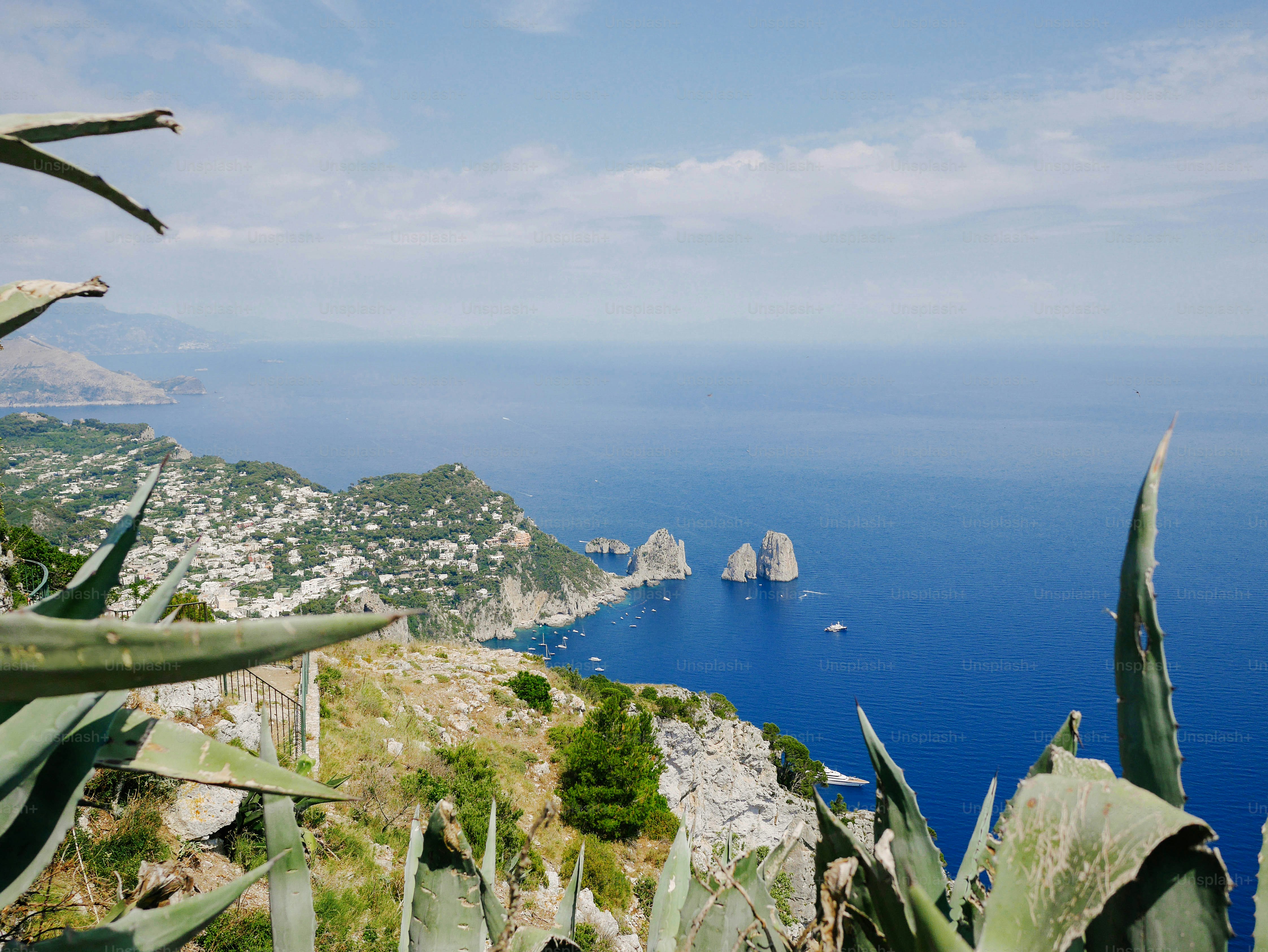 A scenic view of a beach with boats in the water photo – Capri Image on ...