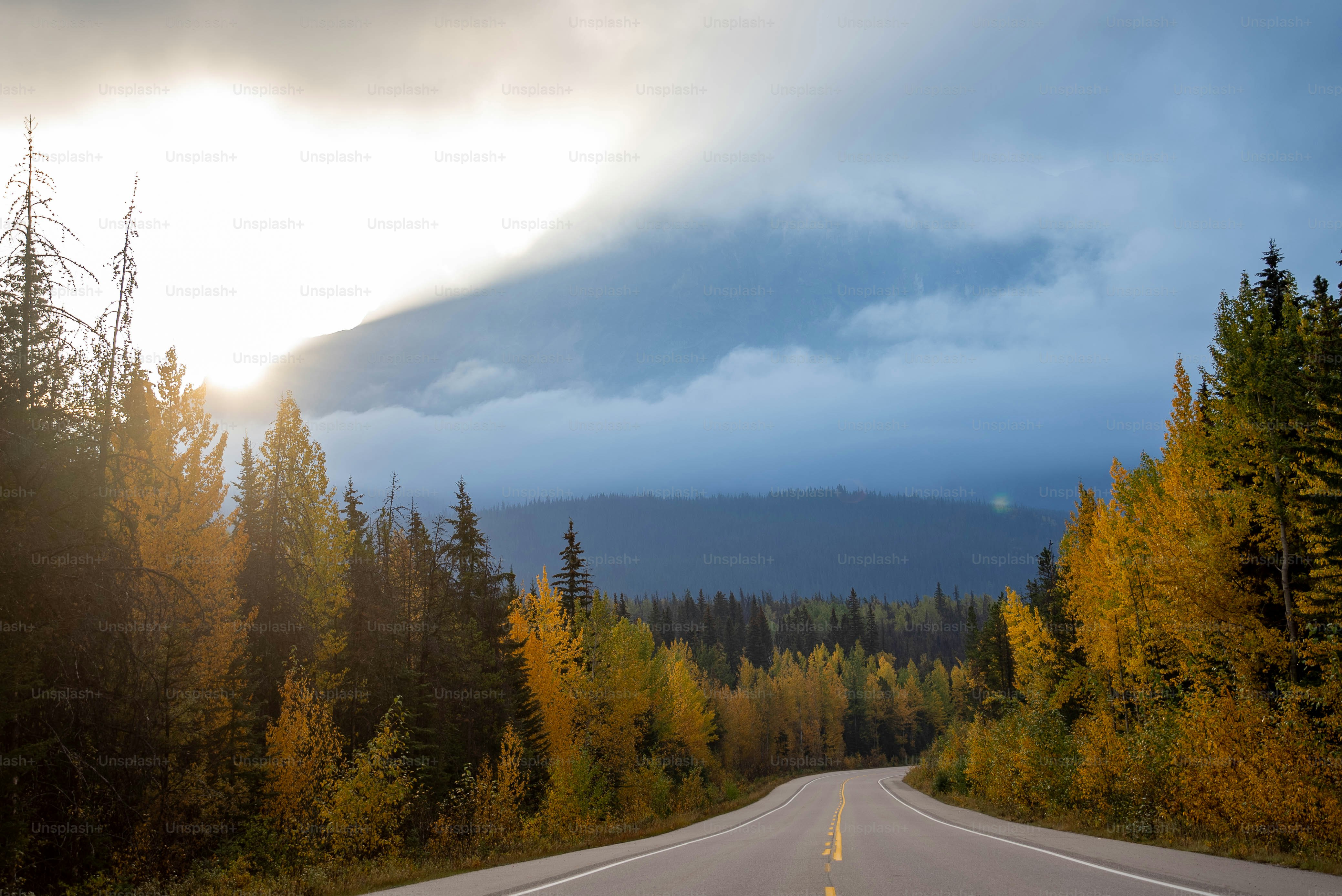 A long road with a mountain in the background photo – Road Image on ...